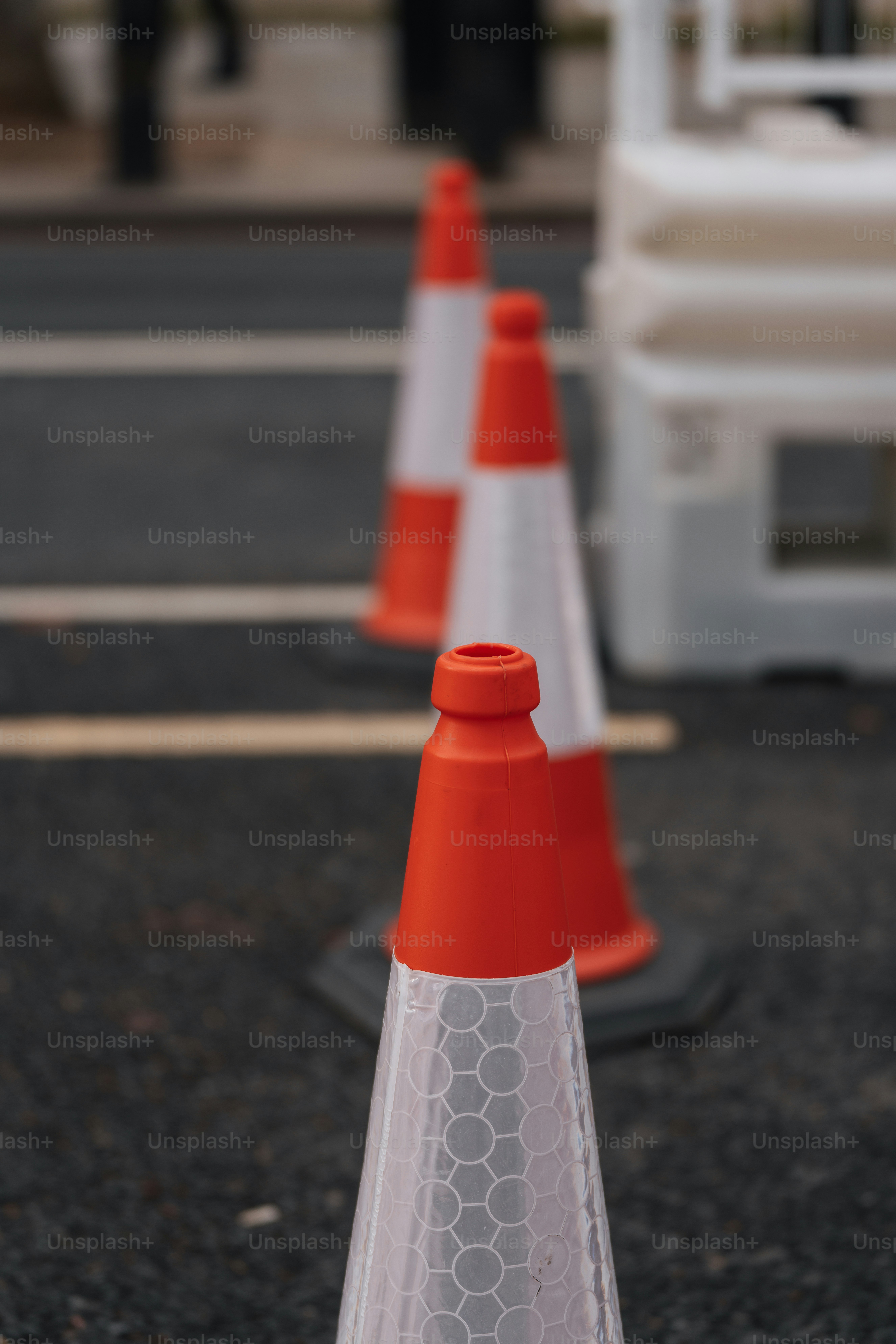 A row of orange and white cones sitting on the side of a road photo ...