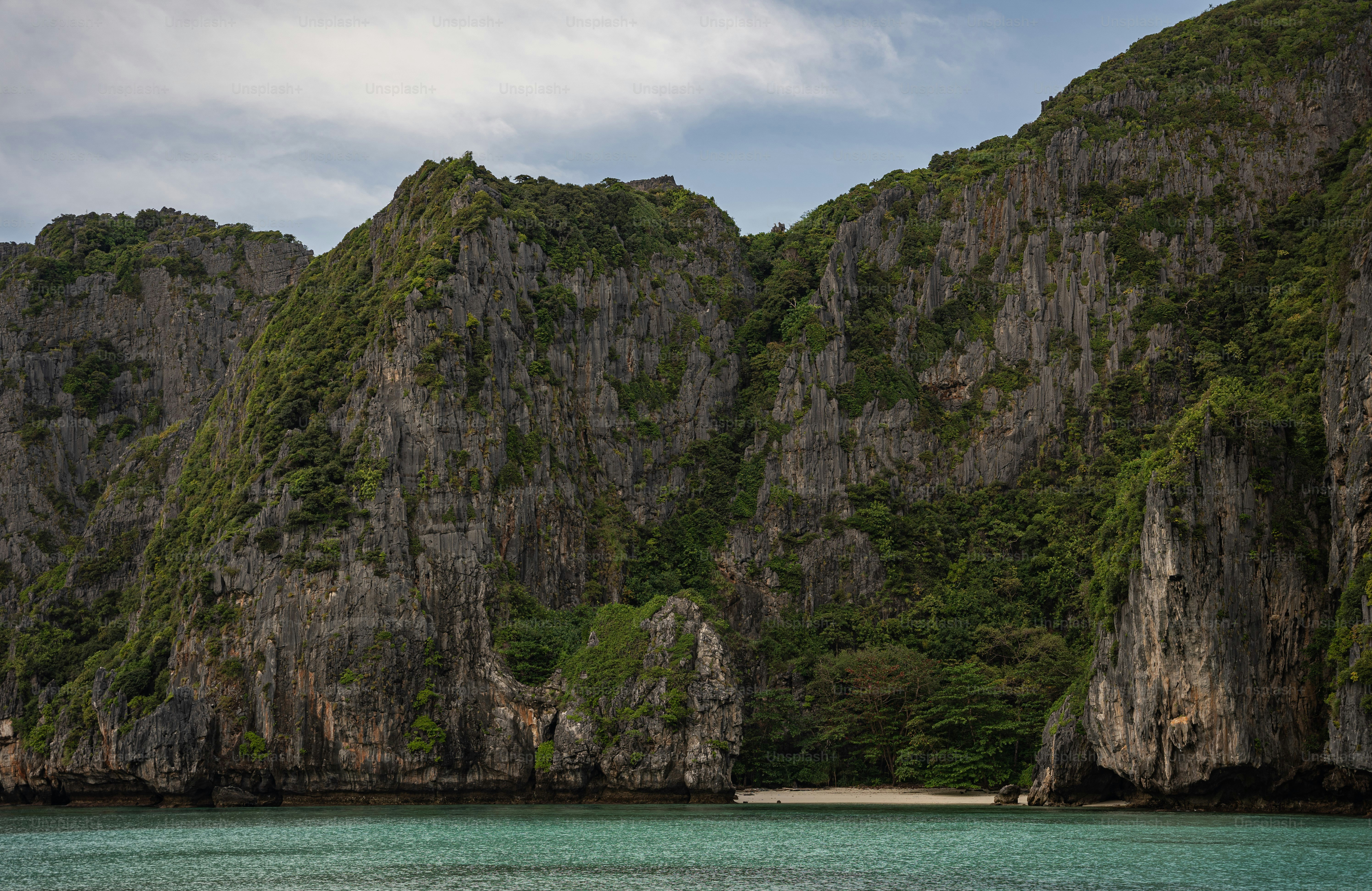 A view of a bay with boats and mountains in the background photo ...