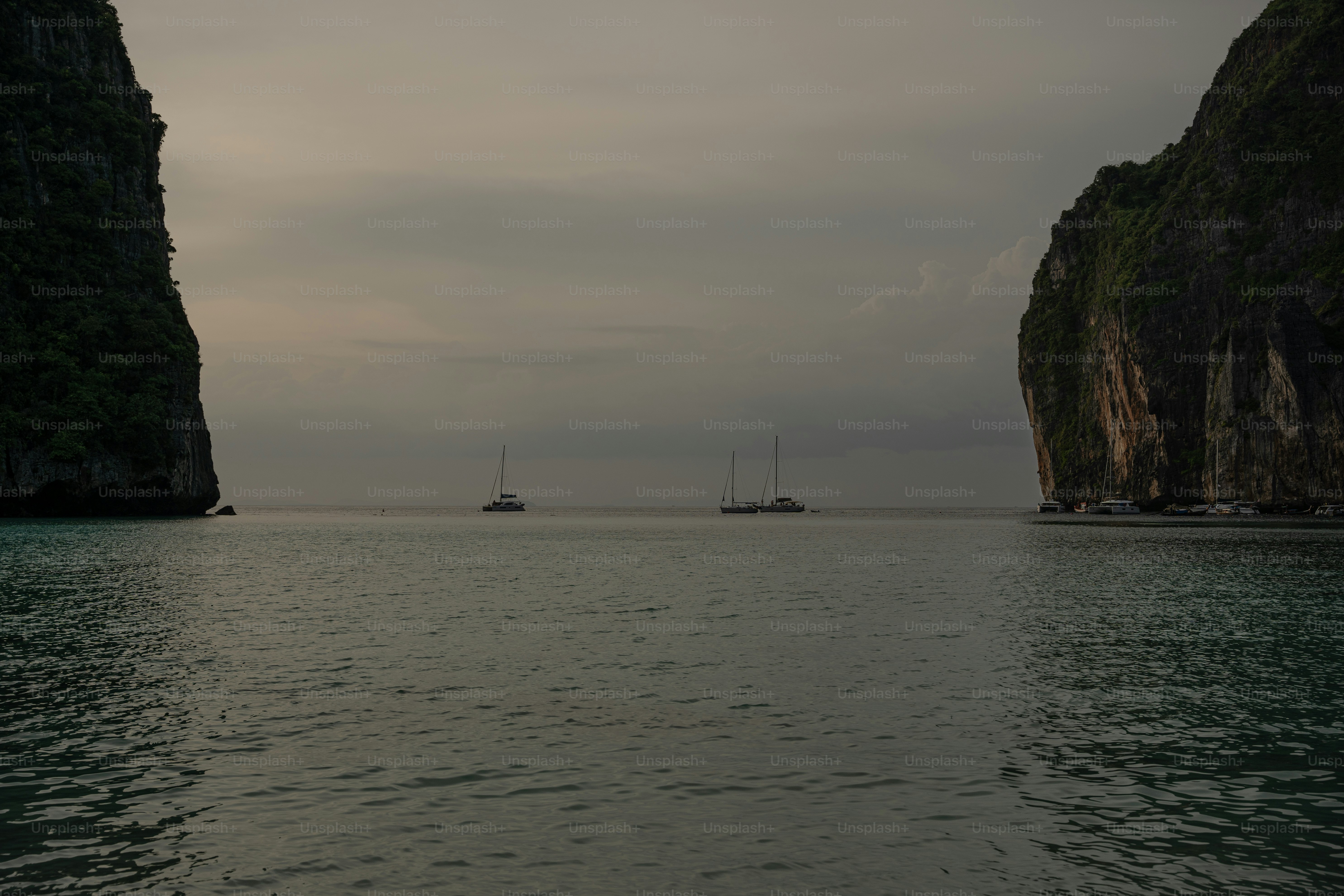 A view of a bay with boats and mountains in the background photo ...