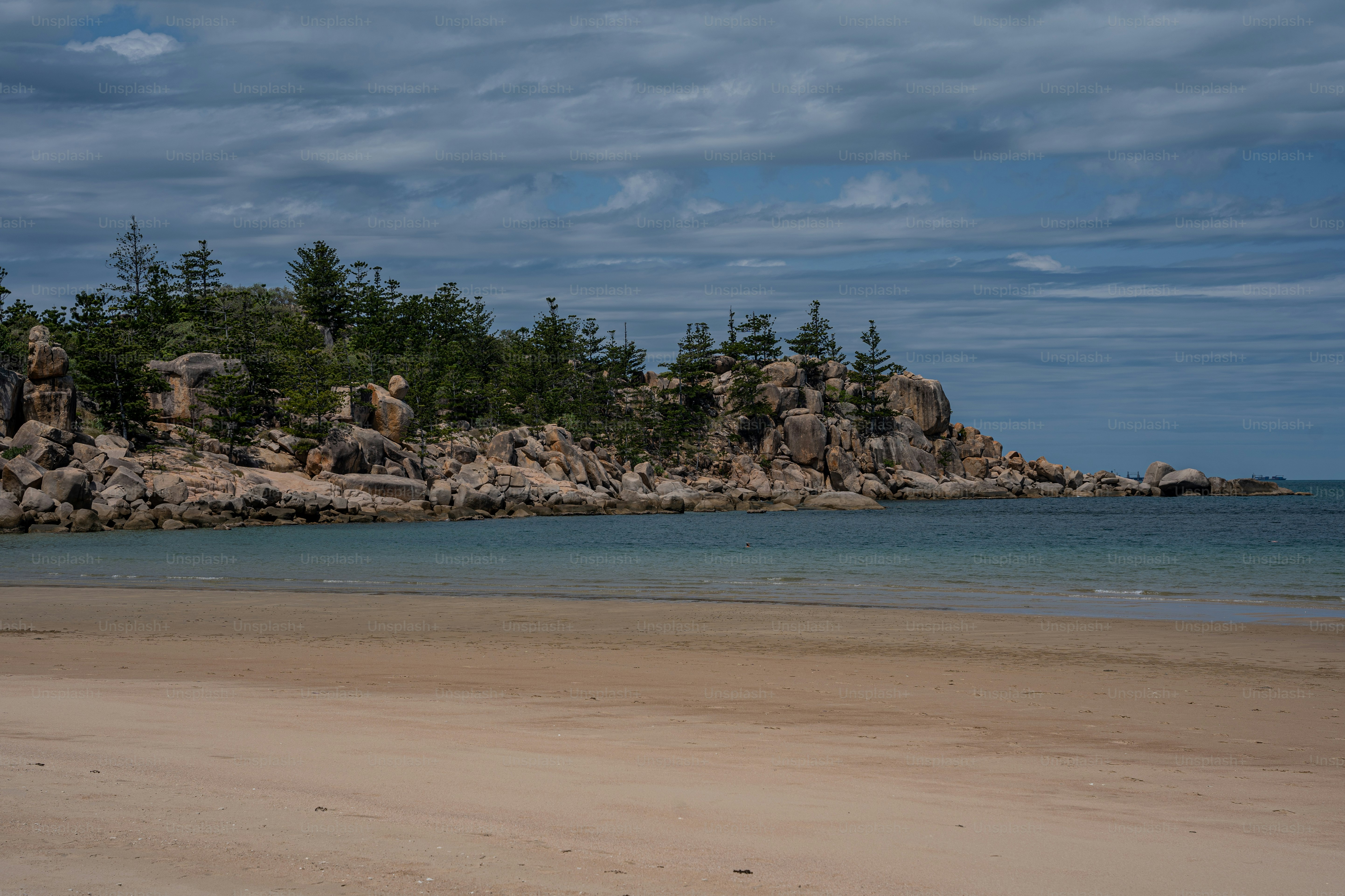A sandy beach next to a forest covered island photo – Wallpaper Image ...