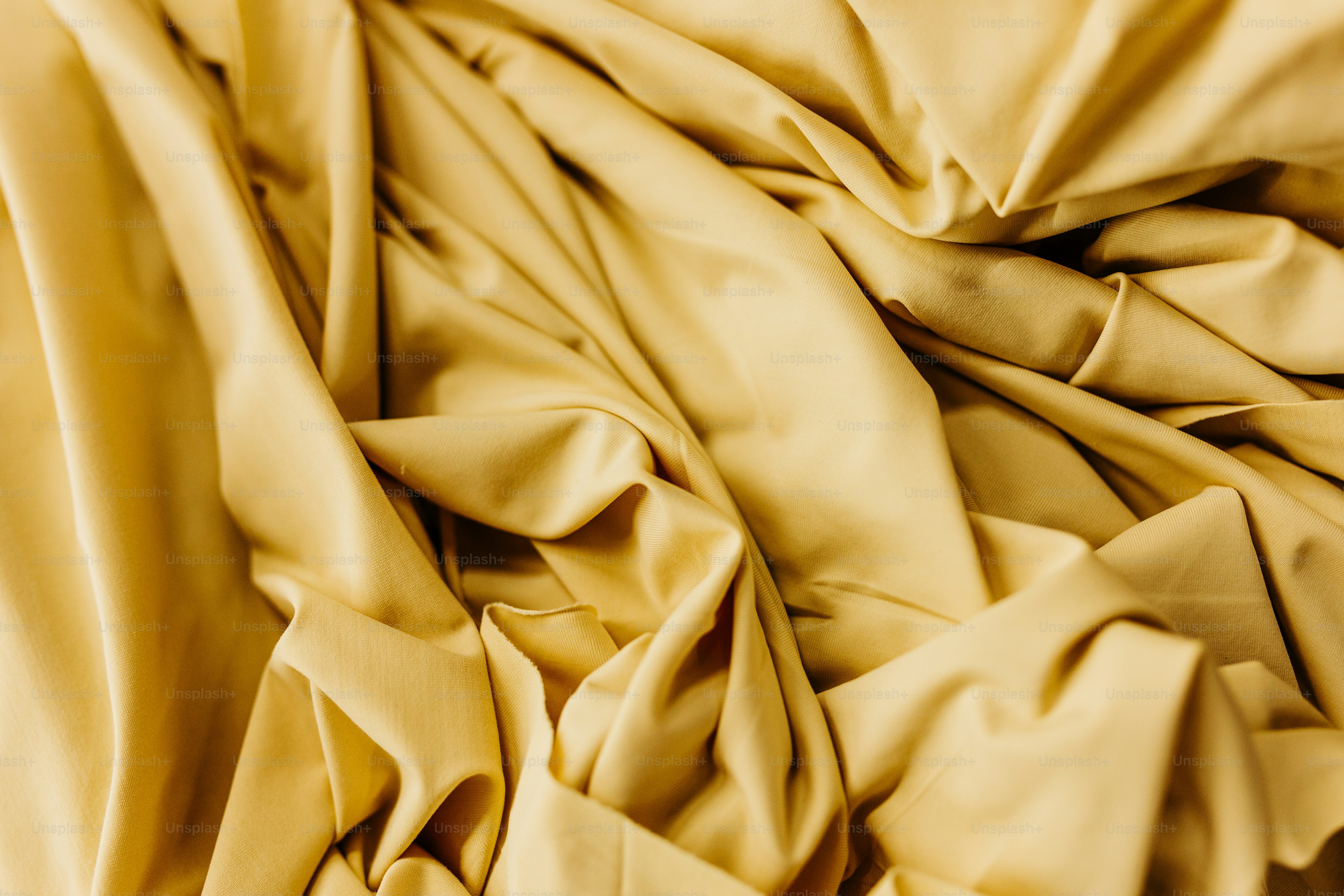 A close up of a bed with a yellow comforter photo – Cloth Image on Unsplash