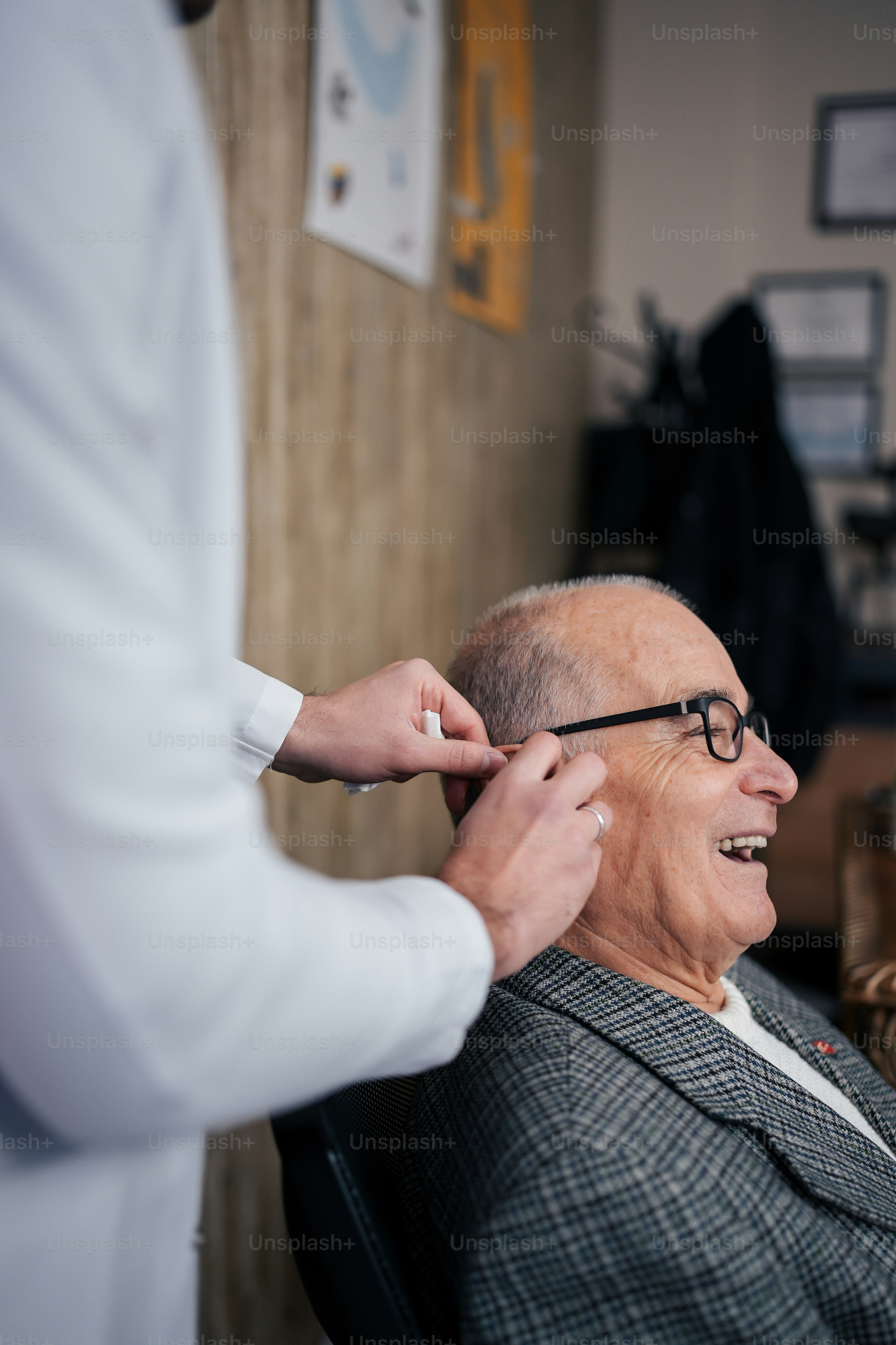 An older man getting his ear checked by a doctor photo – Healthcare ...