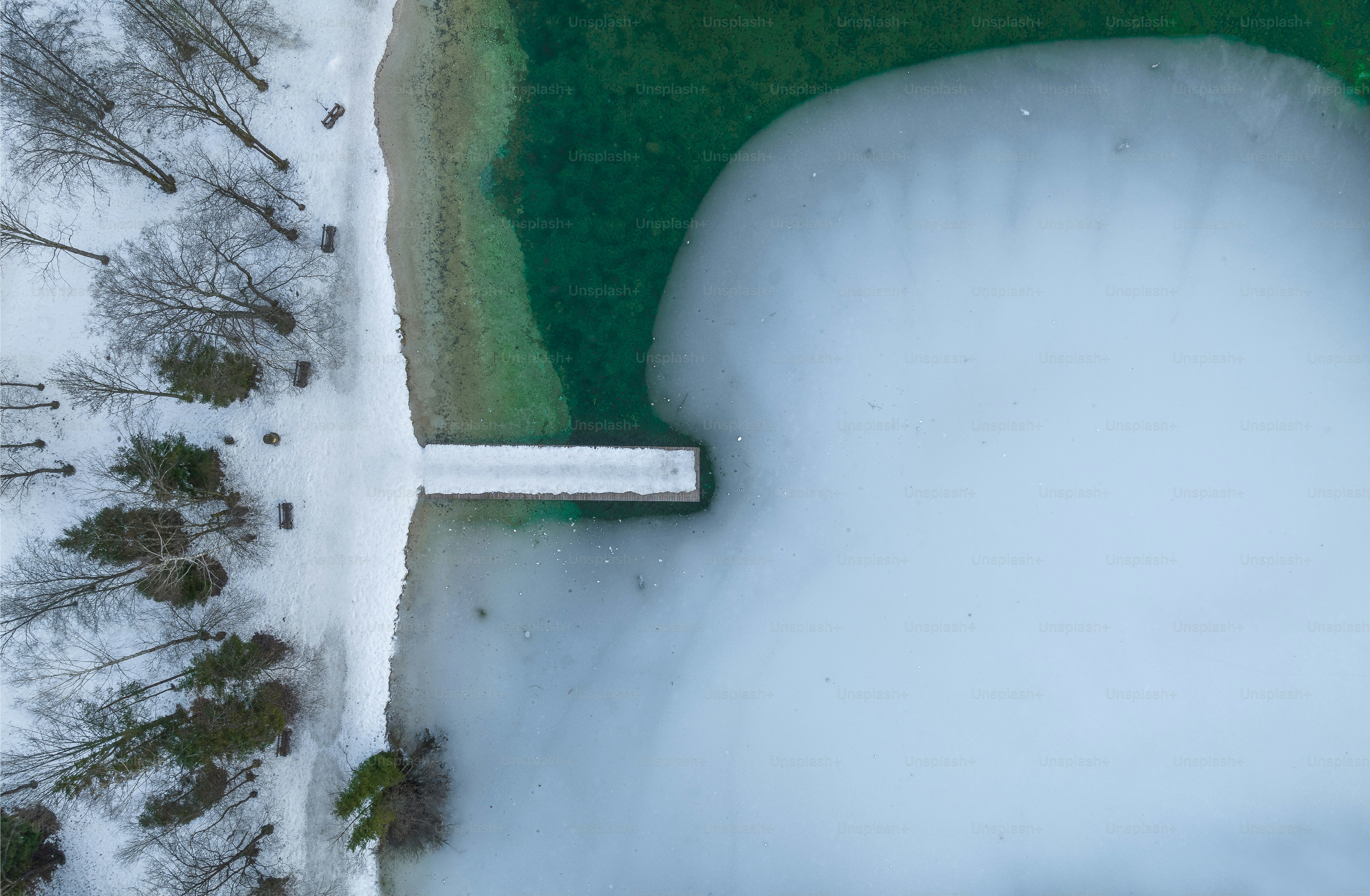 An aerial view of a lake surrounded by snow photo – River Image on Unsplash