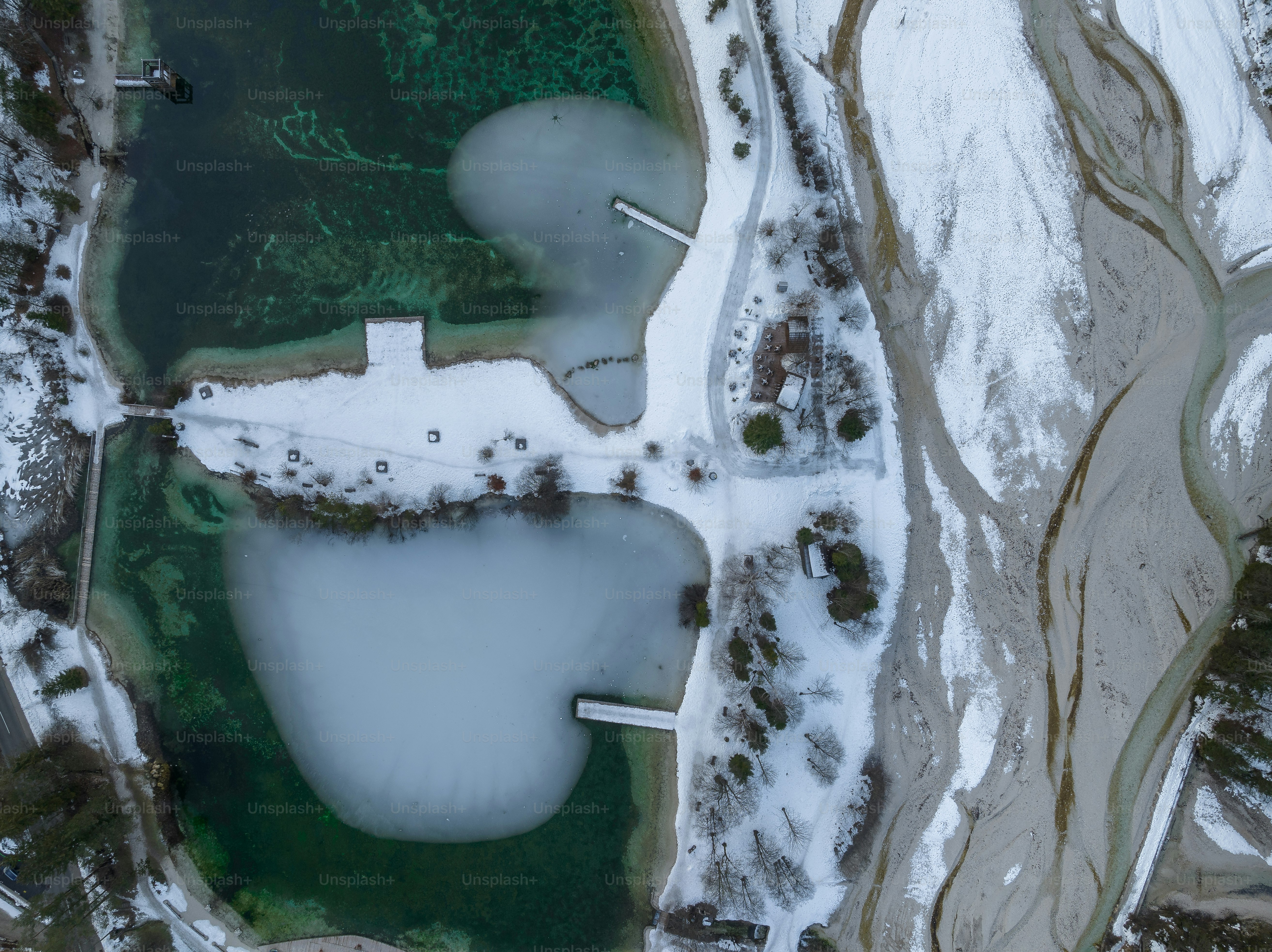 An aerial view of a lake surrounded by snow photo – River Image on Unsplash
