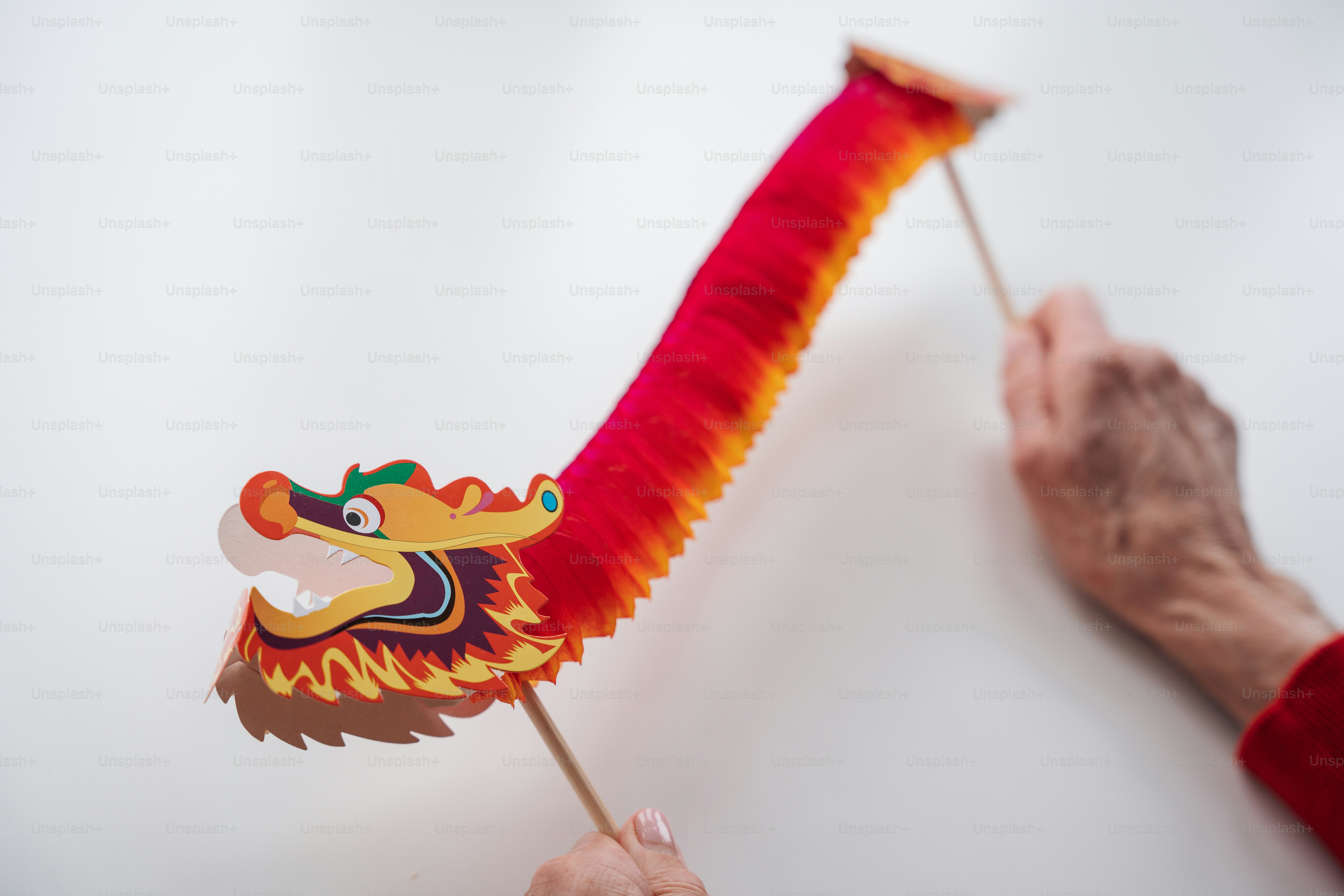 A hand holding a red and yellow dragon puppet photo – Chinese new year ...