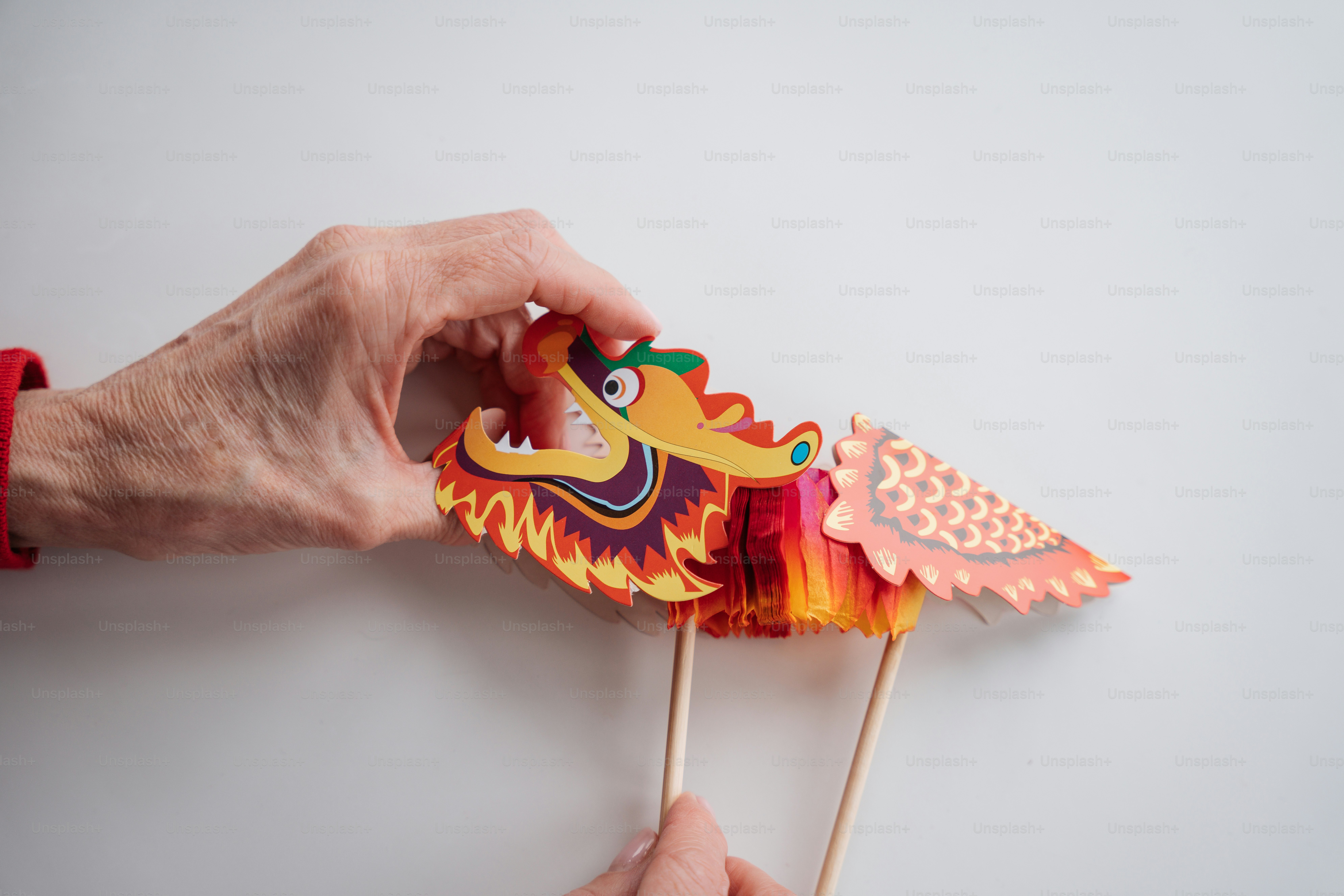 A person holding a dragon shaped toothpick on a stick photo – Dragon ...