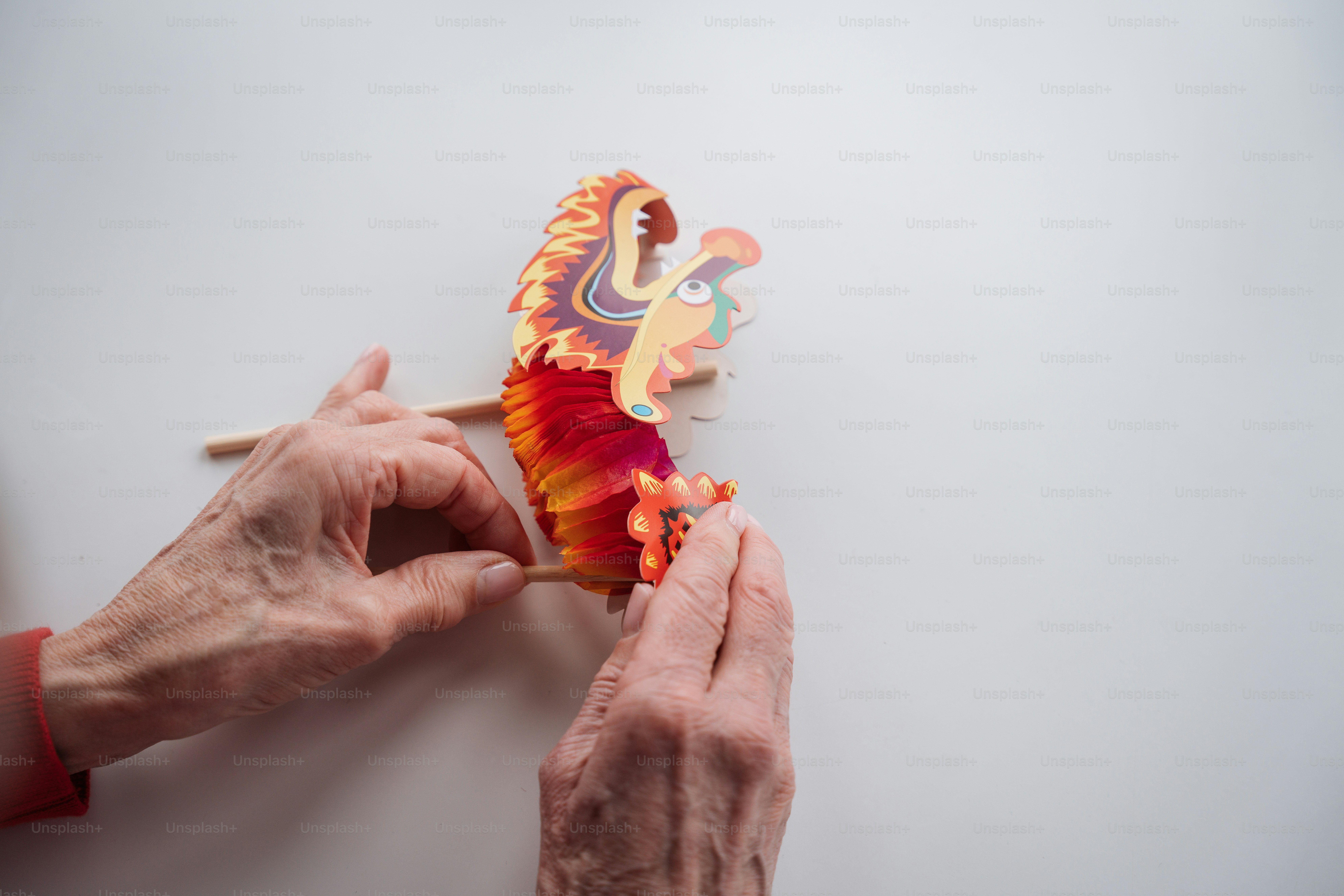A person holding a colorful kite on top of a table photo – Lunar new ...