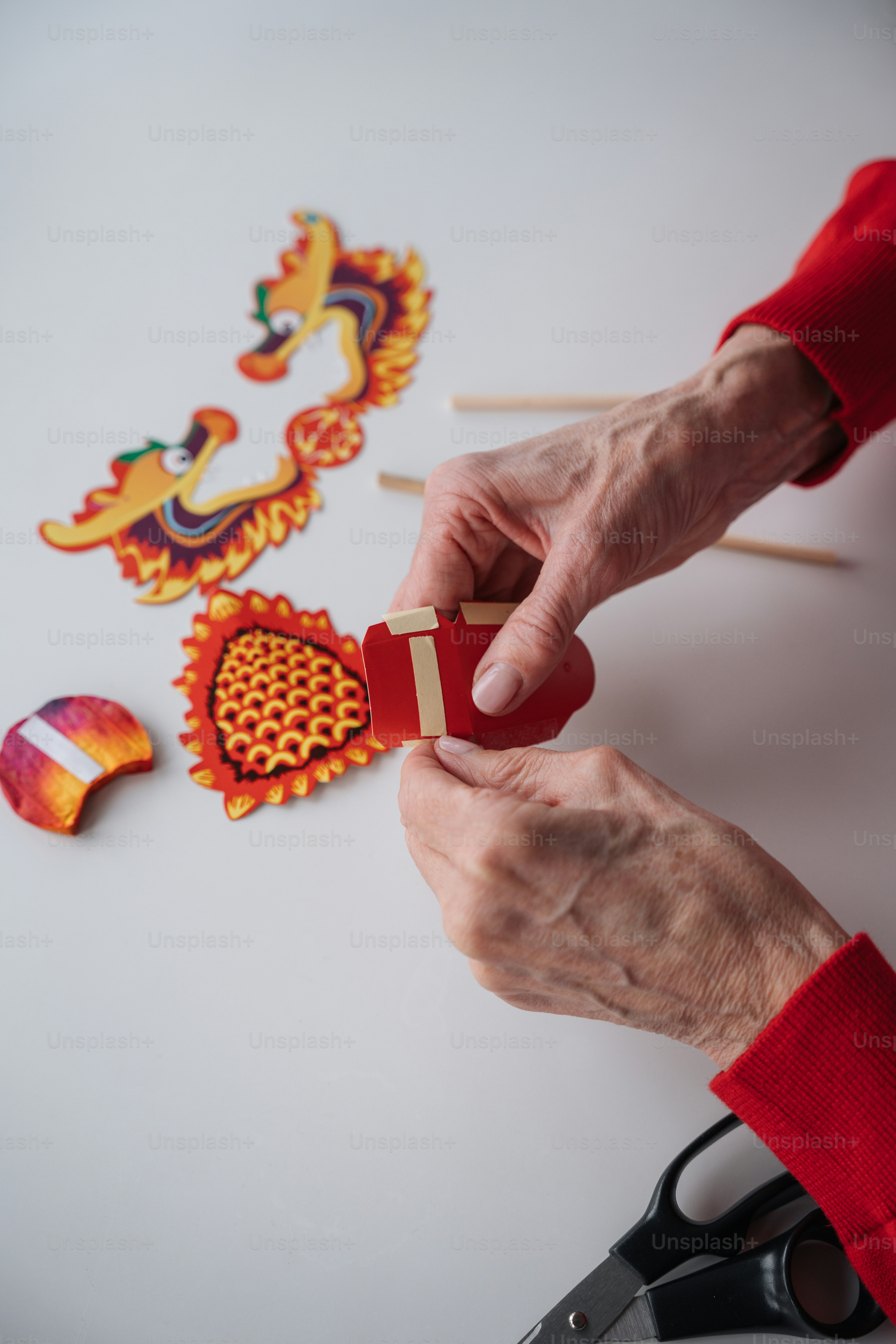 A person holding a pair of scissors over a piece of paper photo – Lunar ...