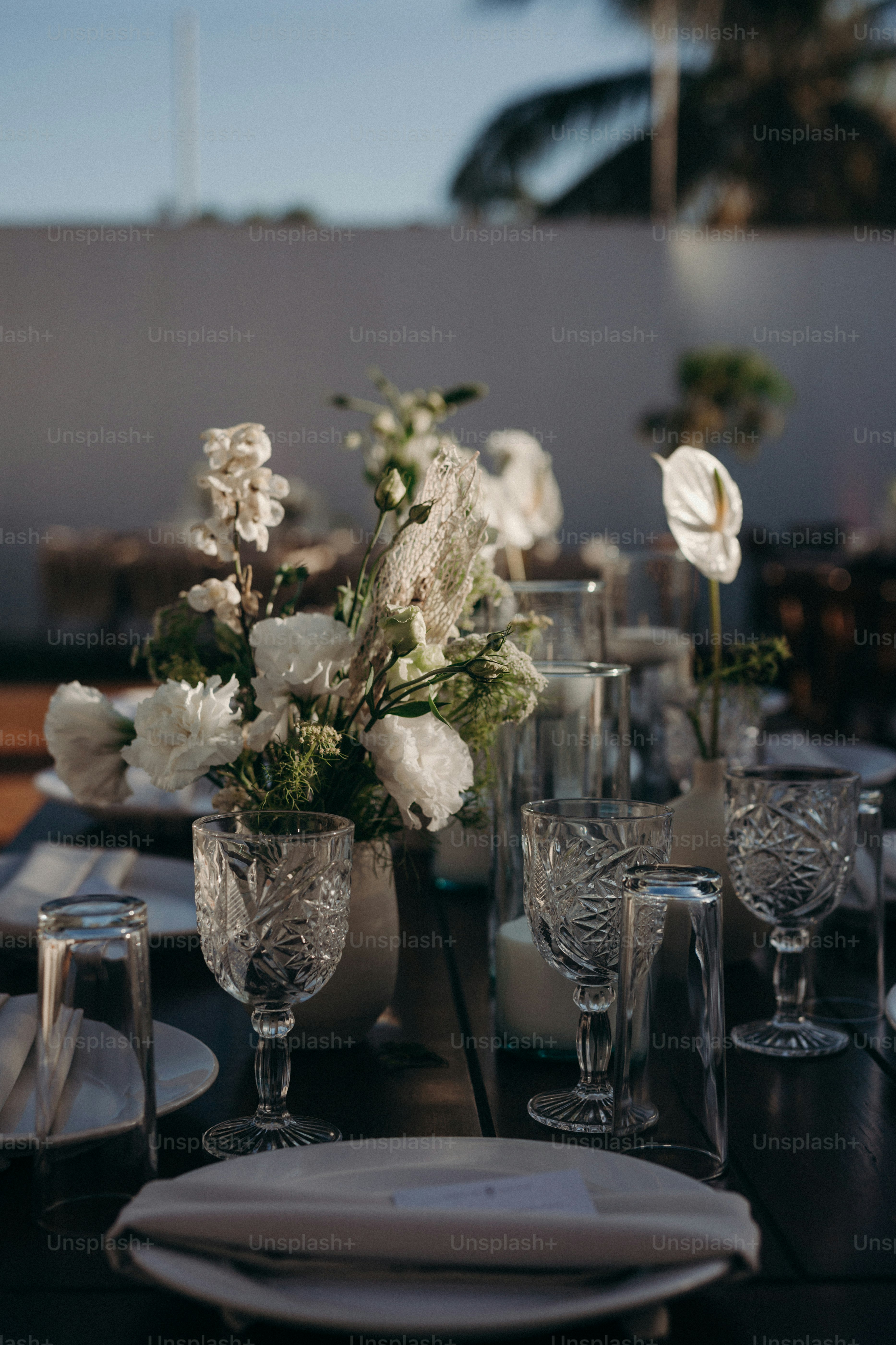 A table set for a formal dinner with flowers in vases photo – Table ...