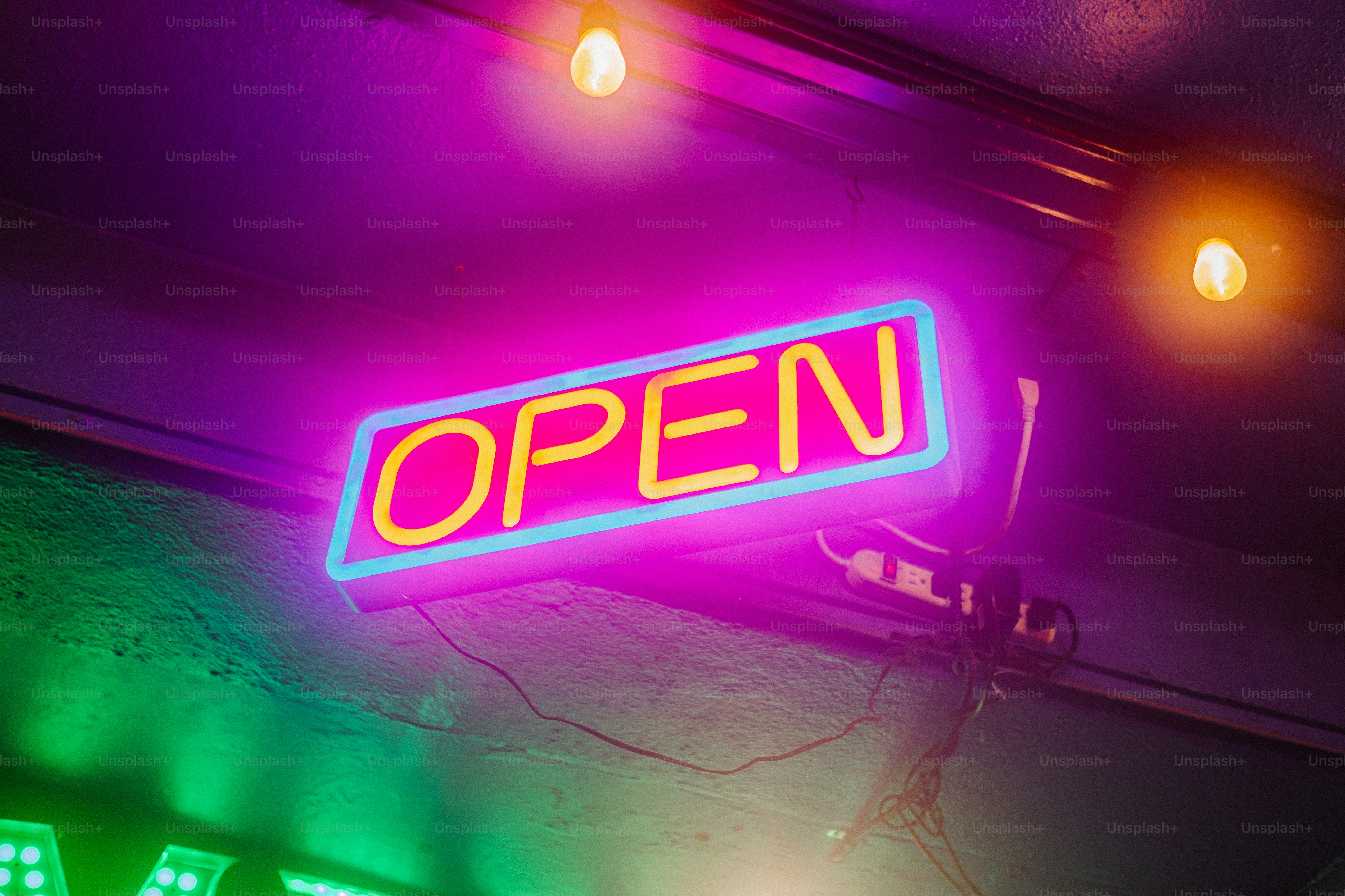 A neon sign that says open above a neon sign photo – Neon Image on Unsplash