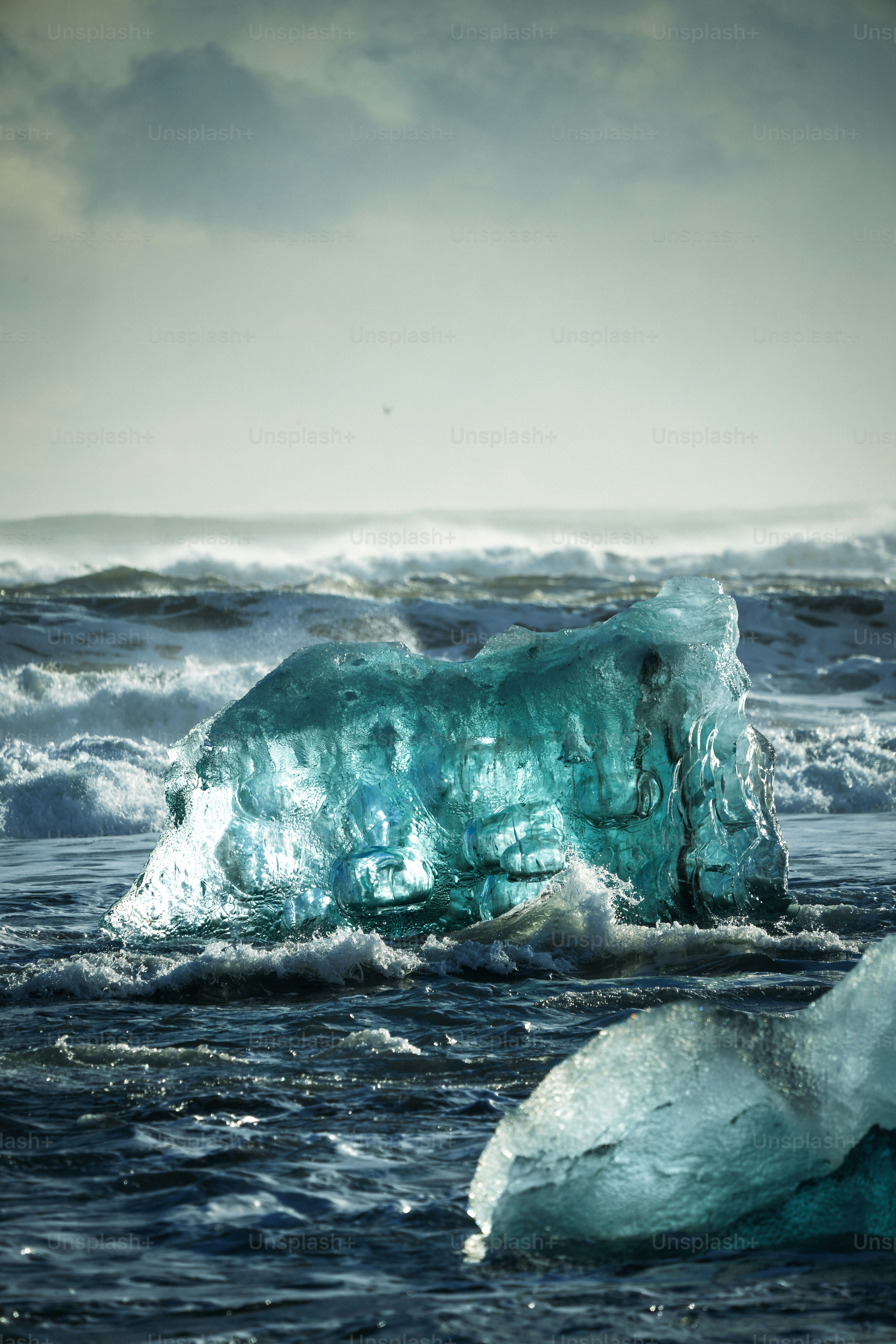 A large iceberg floating on top of a body of water photo – Iceland ...