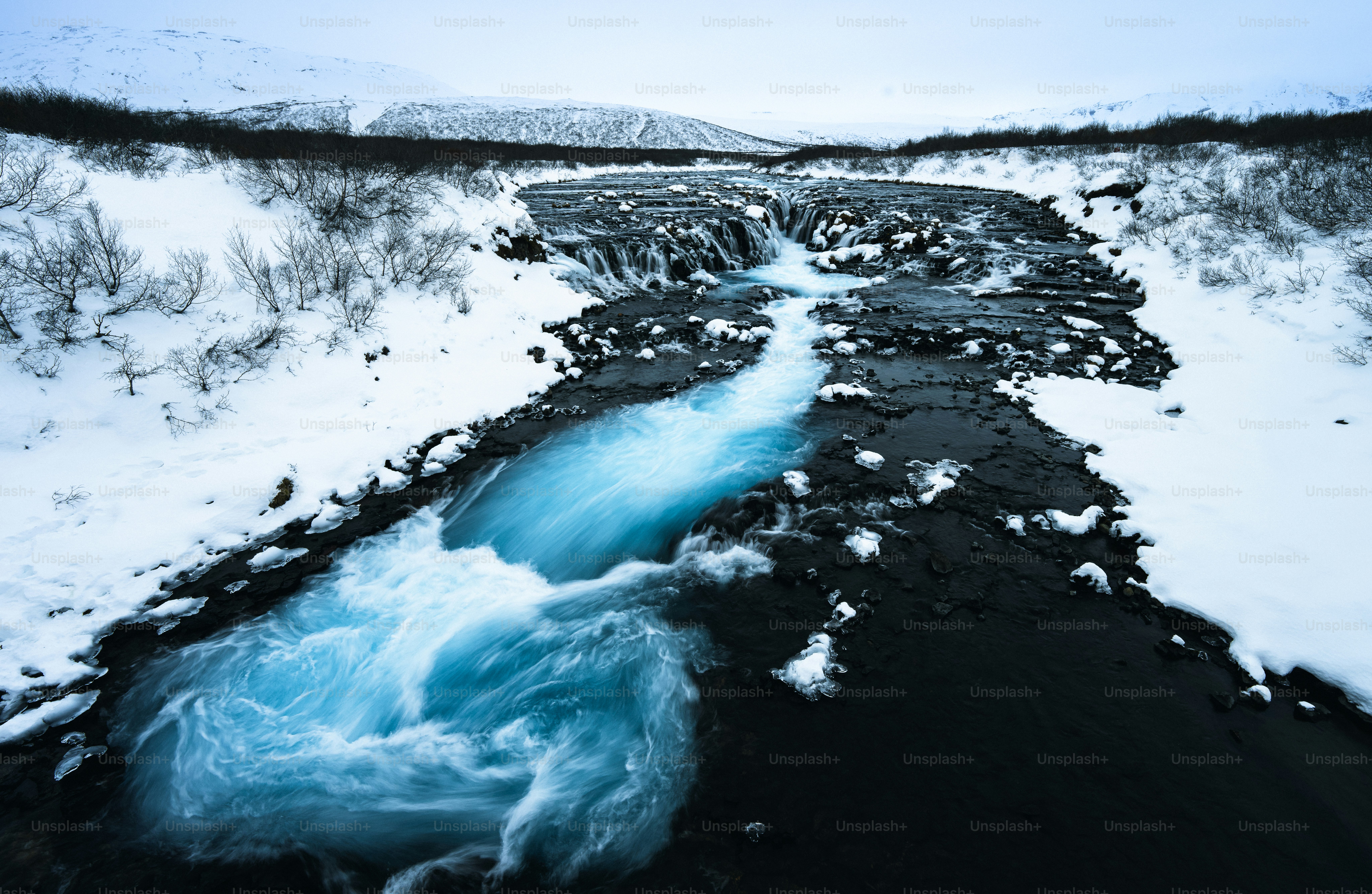 A stream of water running through a snow covered landscape photo ...