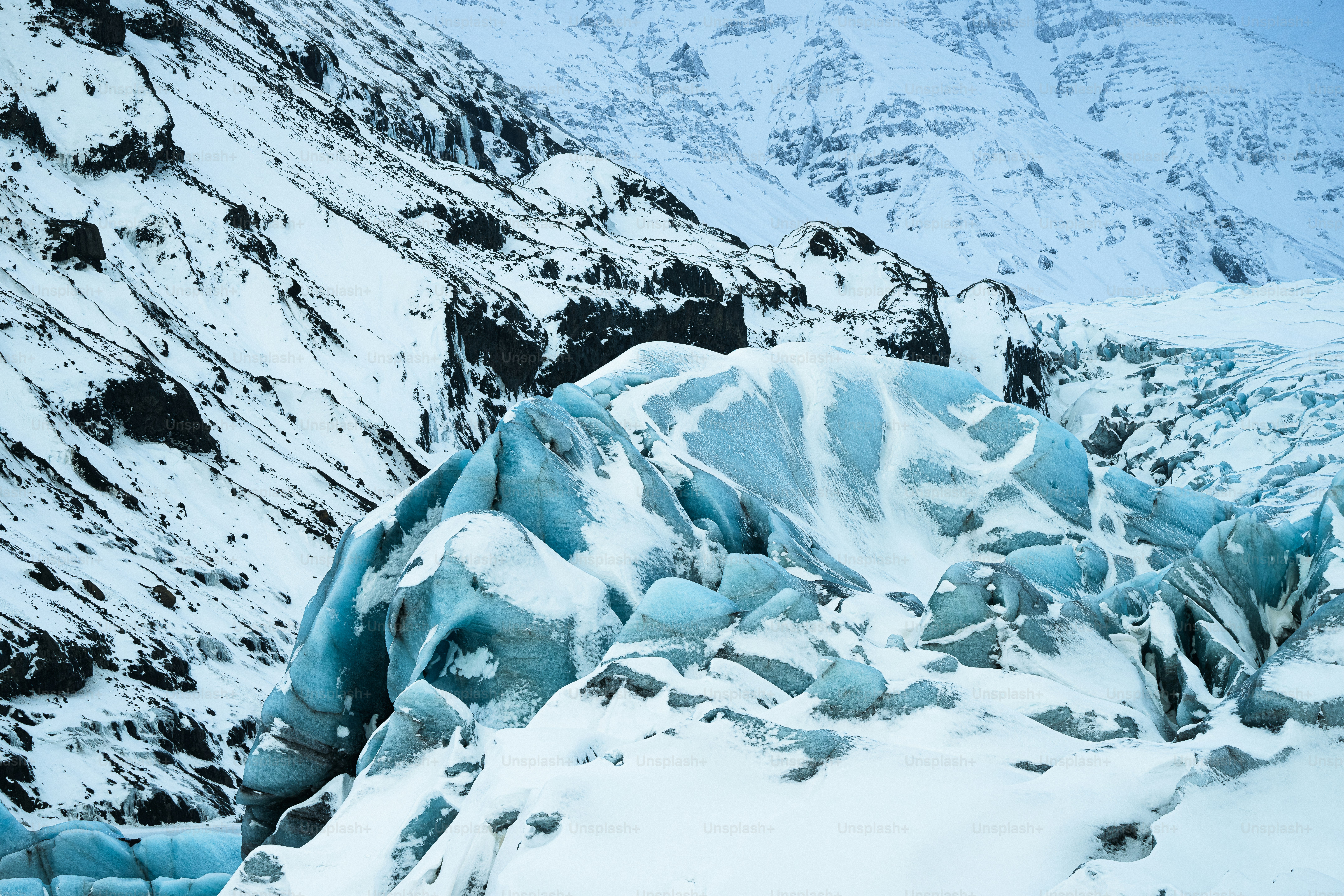 A snow covered mountain side with a bunch of ice on it photo – Iceland ...