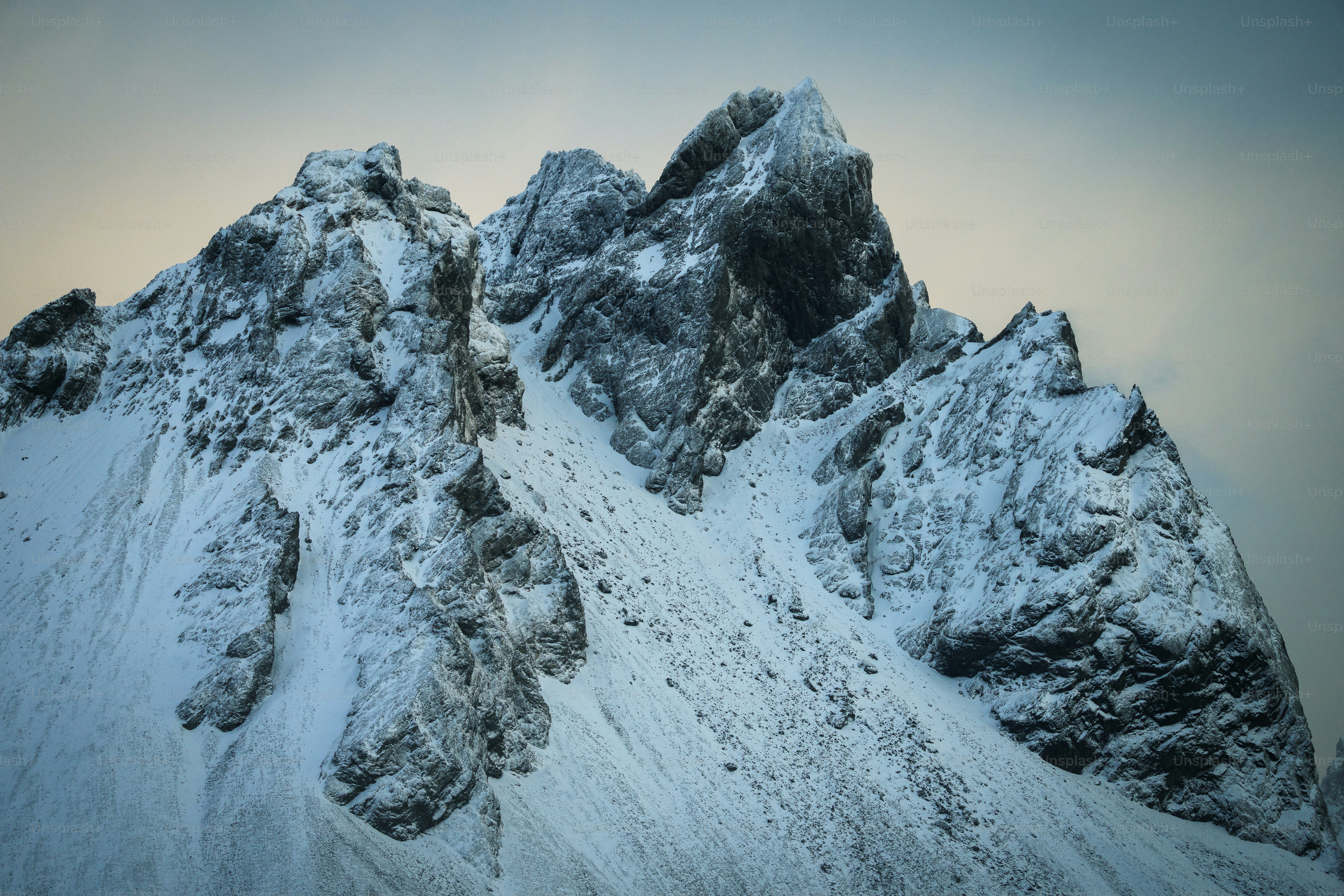 A very tall mountain covered in snow under a cloudy sky photo – Iceland ...