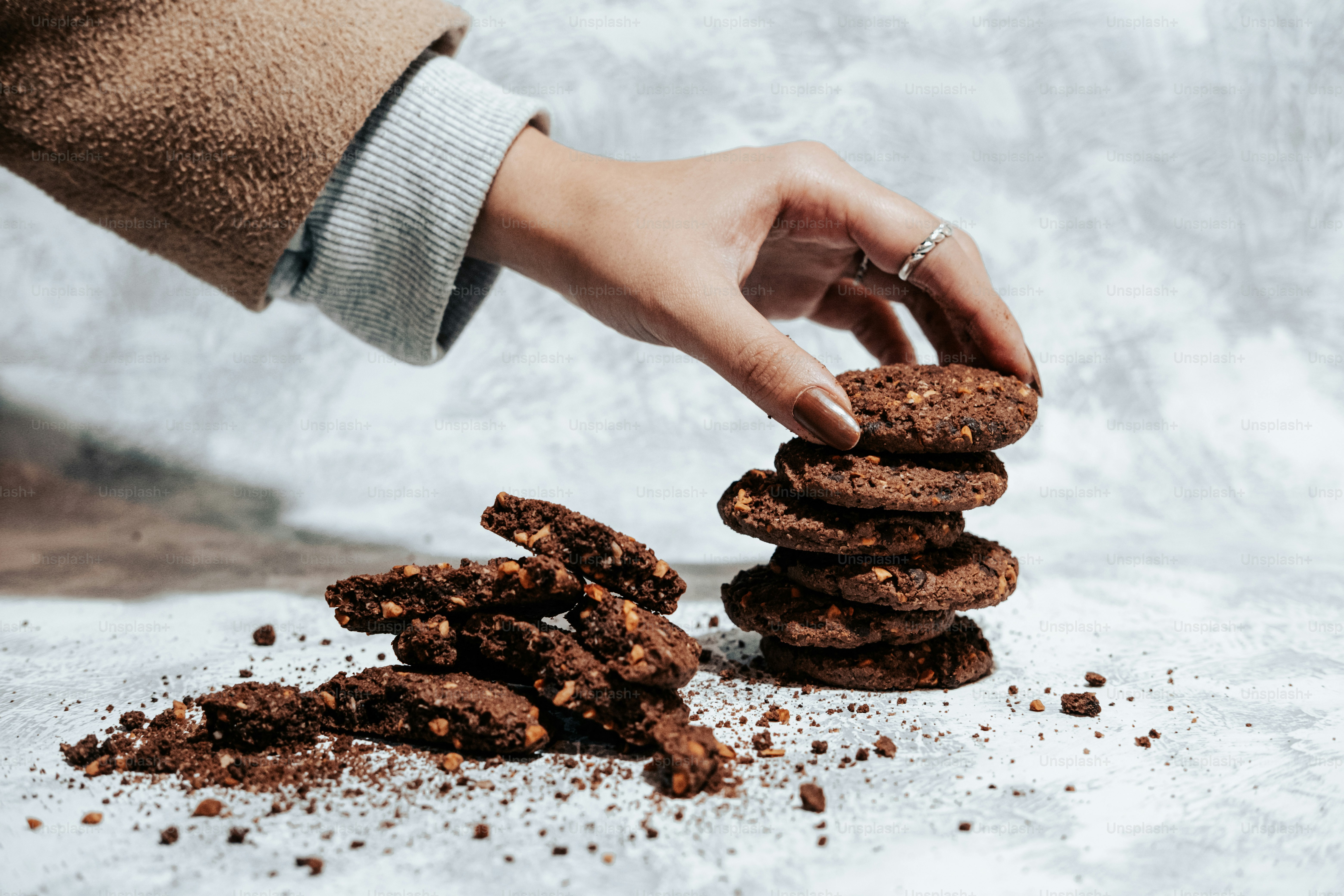 A person reaching for a stack of cookies photo – Broken cookies Image ...