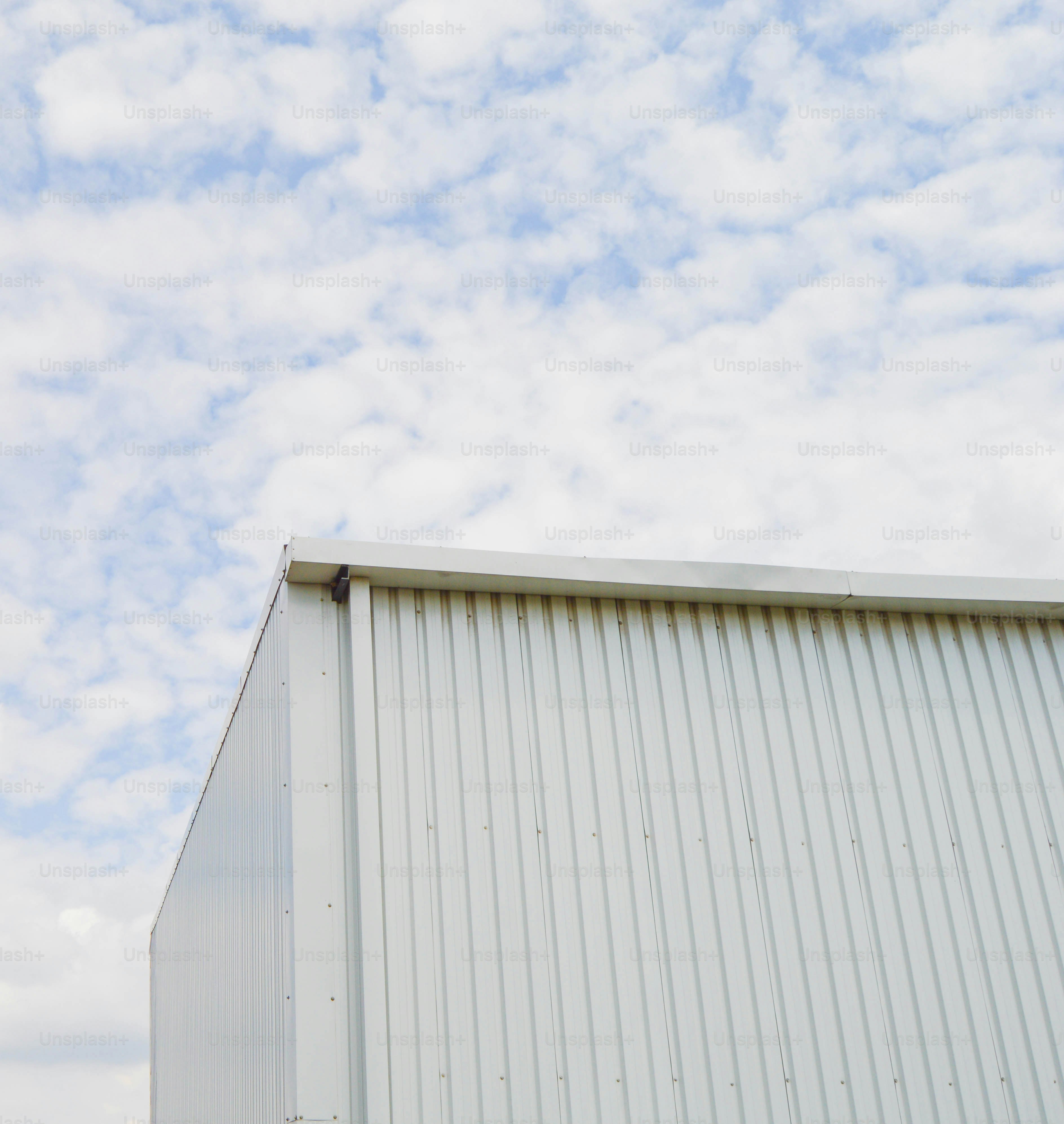 Un avion survolant un bâtiment sous un ciel nuageux photo – Texture du ...