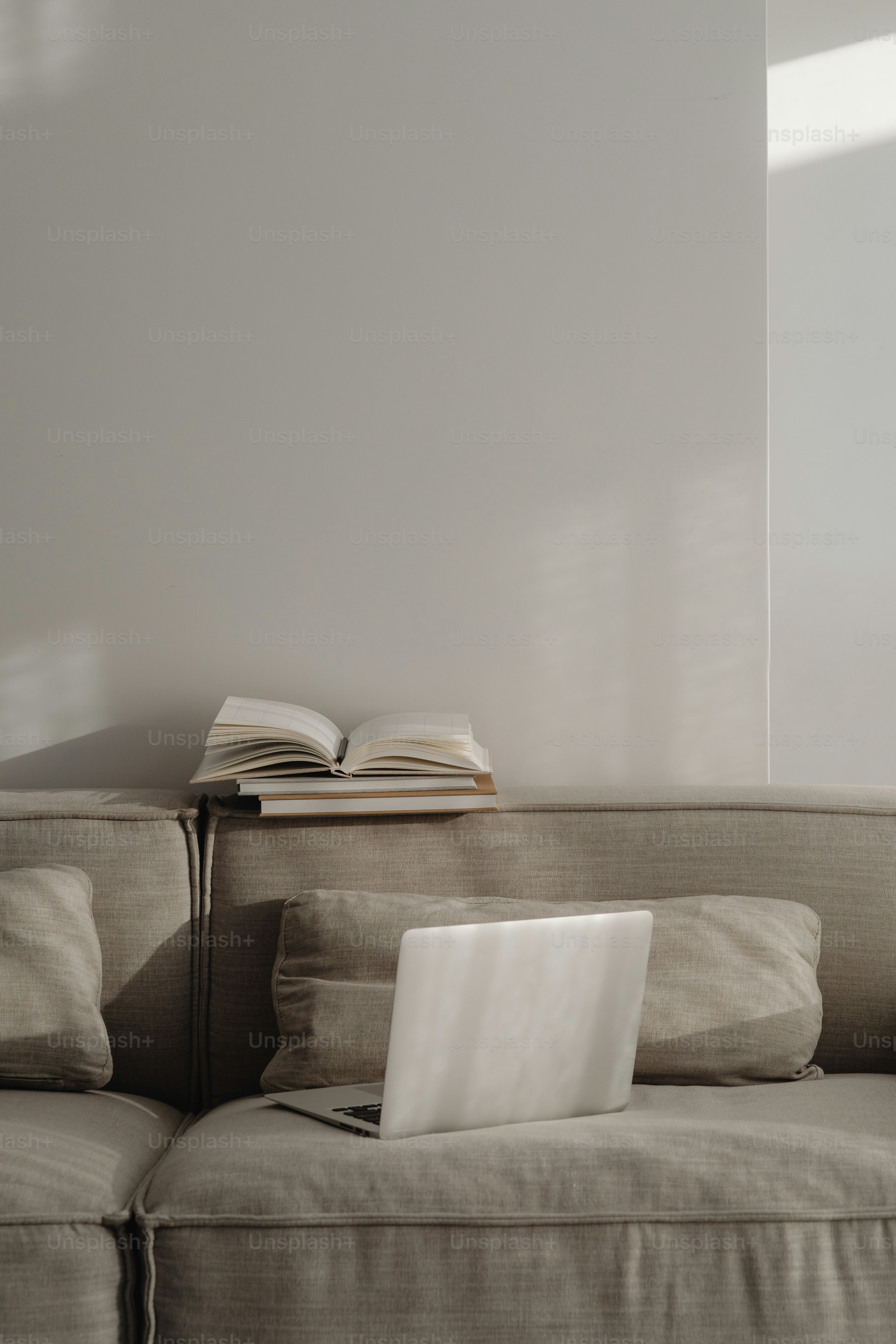A laptop computer sitting on top of a couch photo – White interior ...