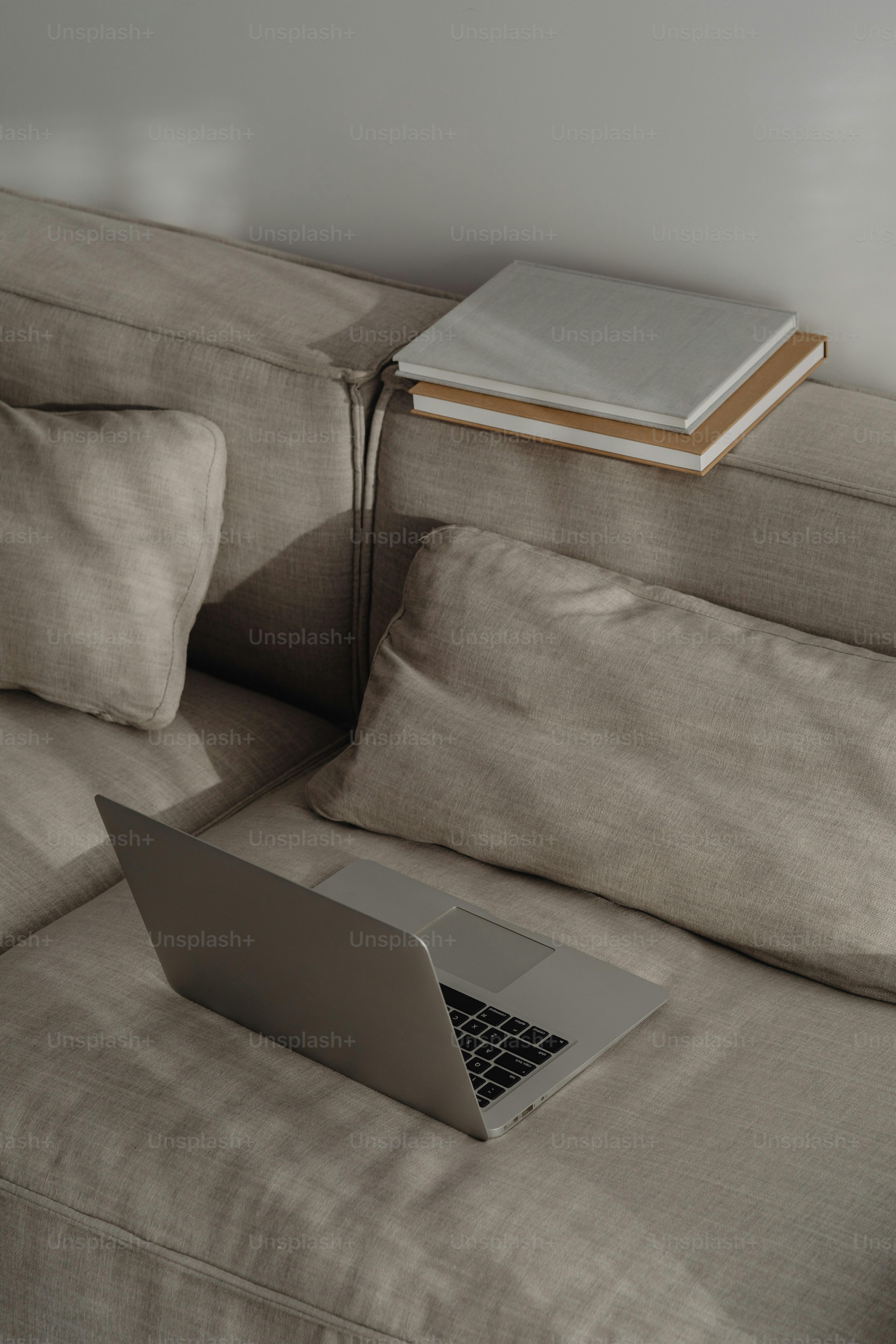 A laptop computer sitting on top of a couch photo – Minimalistic Image ...