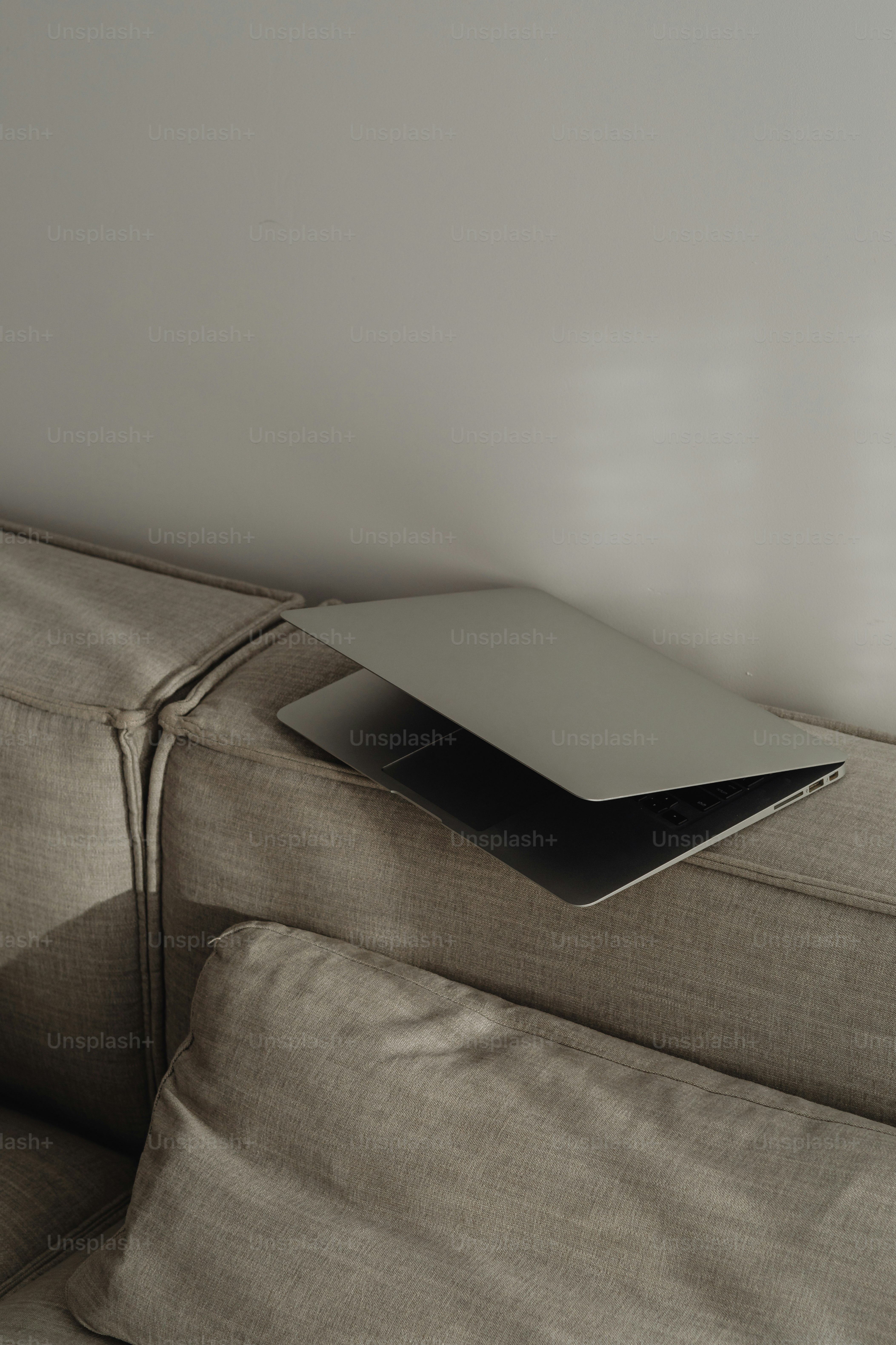 A laptop computer sitting on top of a couch photo – Laptop Image on ...