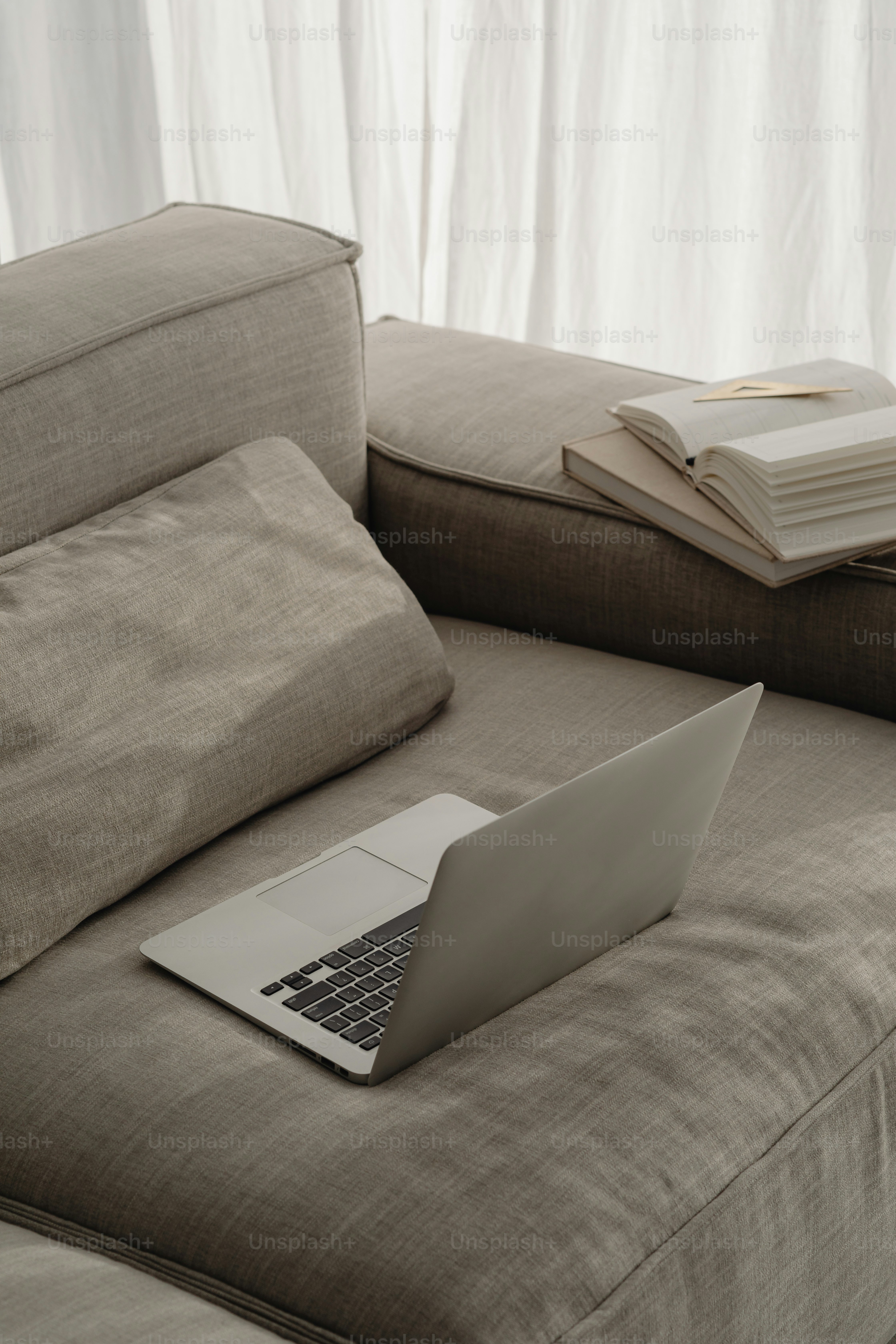 A laptop computer sitting on top of a couch photo – Interior Image on ...