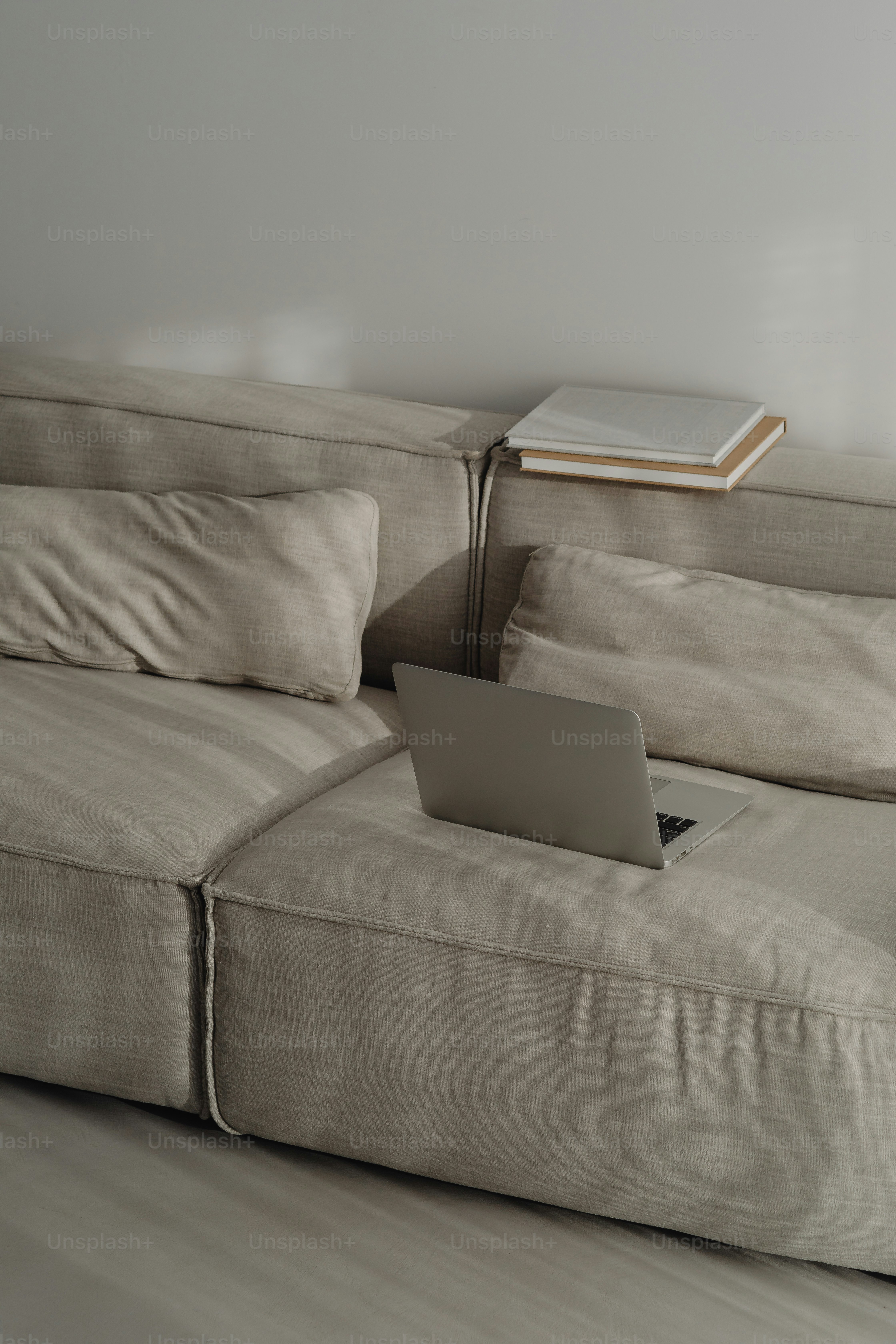 A laptop computer sitting on top of a couch photo – White interior ...
