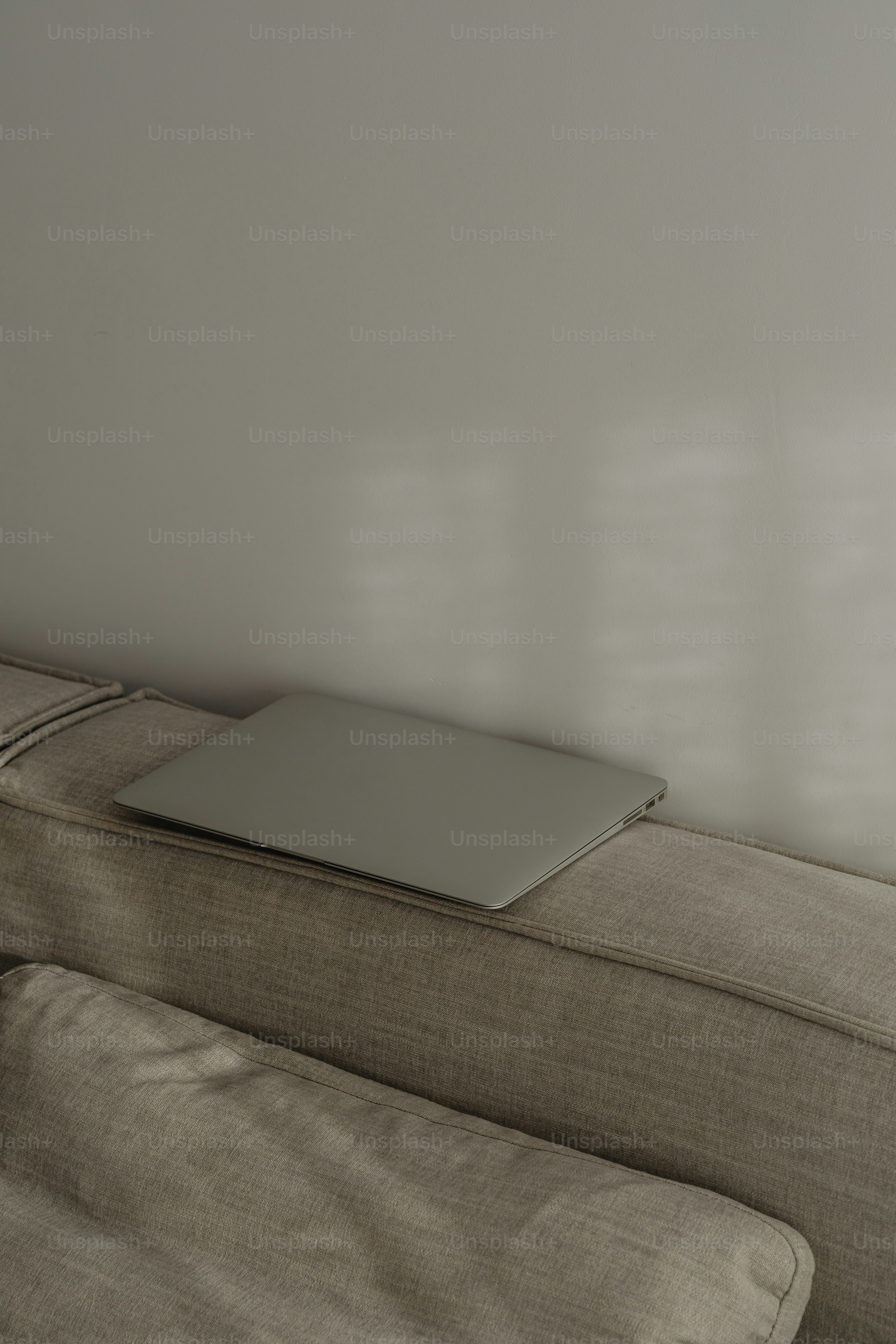 A laptop computer sitting on top of a couch photo – Interior Image on ...