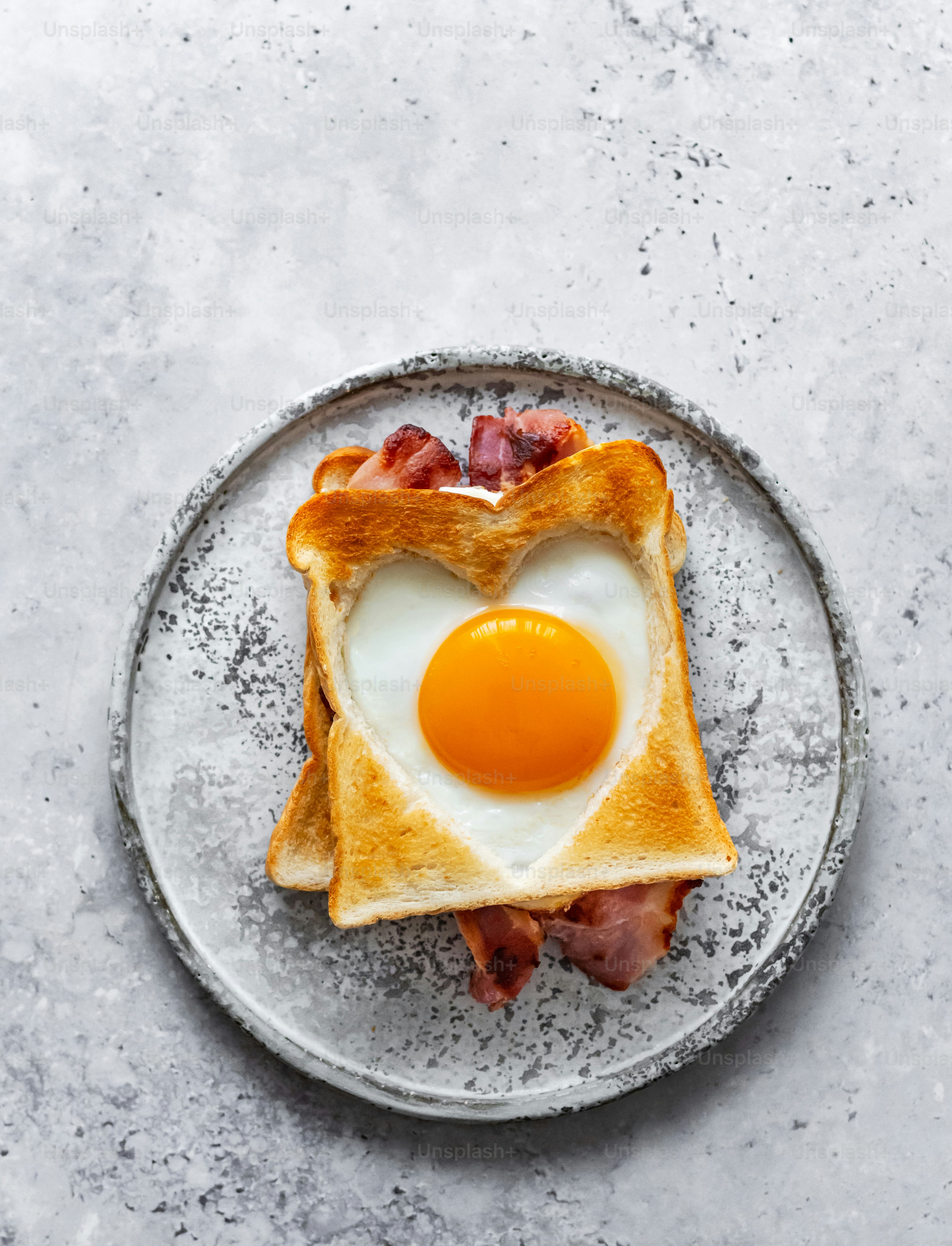 A heart shaped toast with bacon and an egg on top photo – Breakfast ...