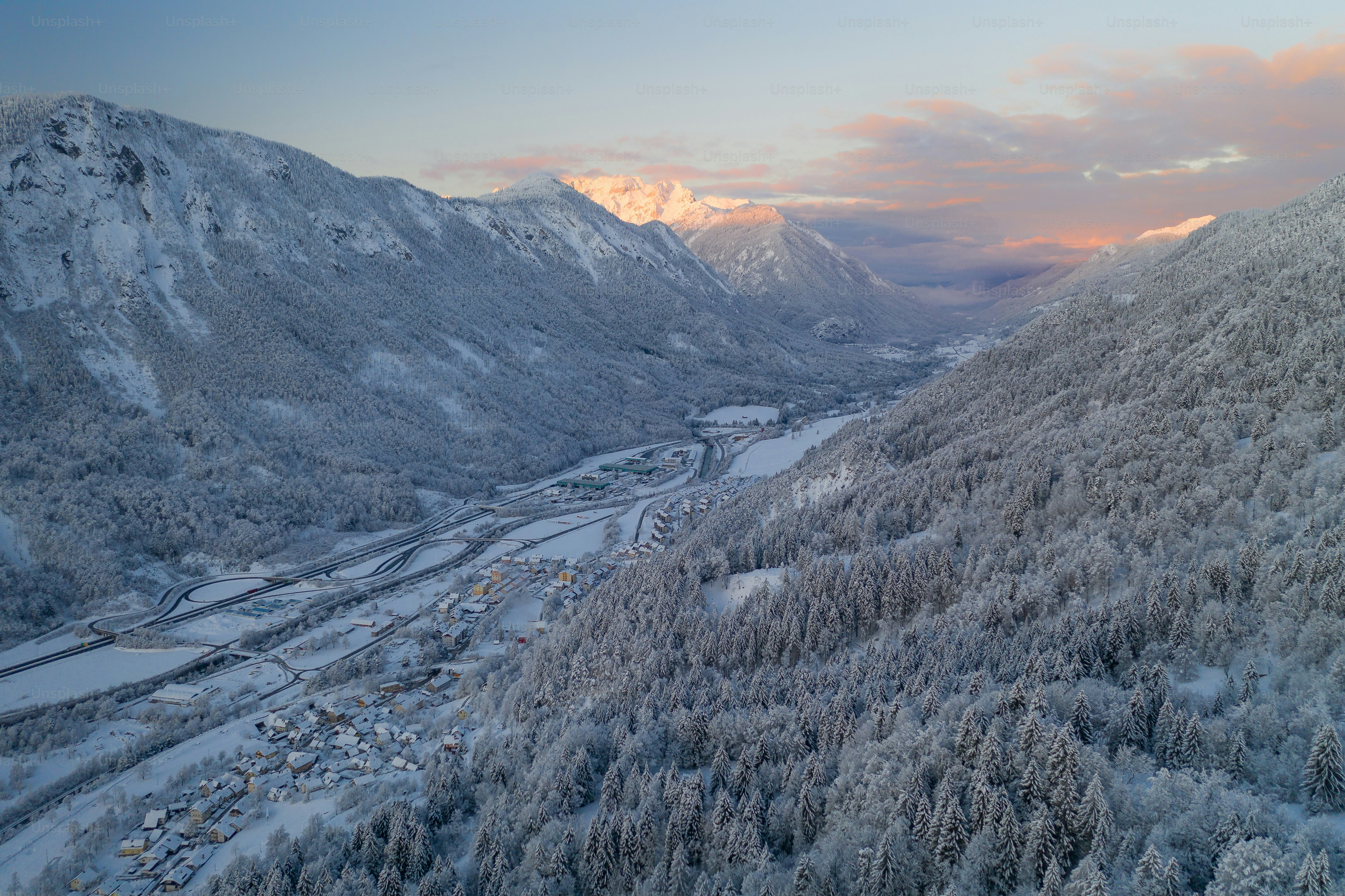 An aerial view of a snowy mountain valley photo – Winter sunset Image ...