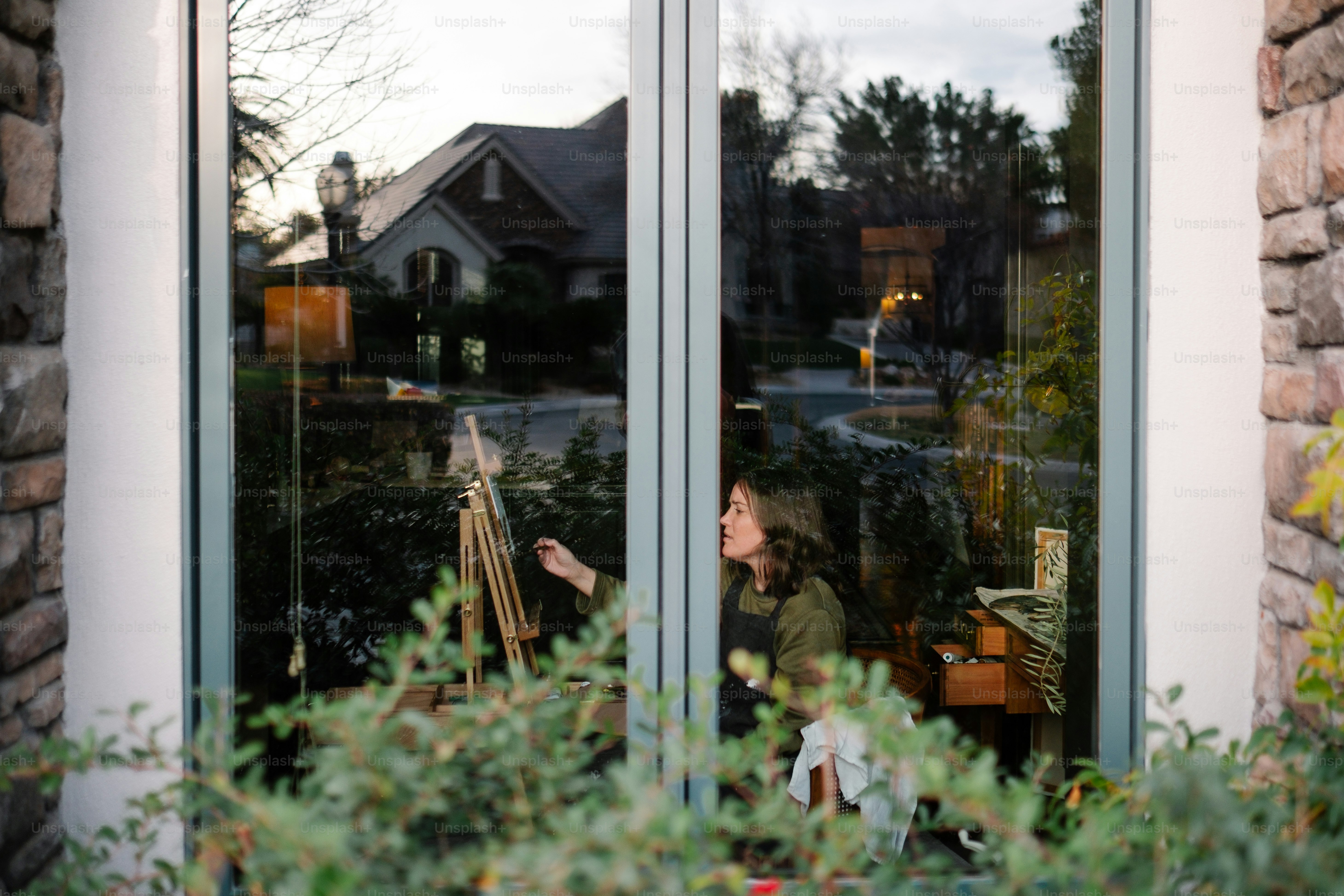 A woman looking out a window at a house photo – Woman Image on Unsplash
