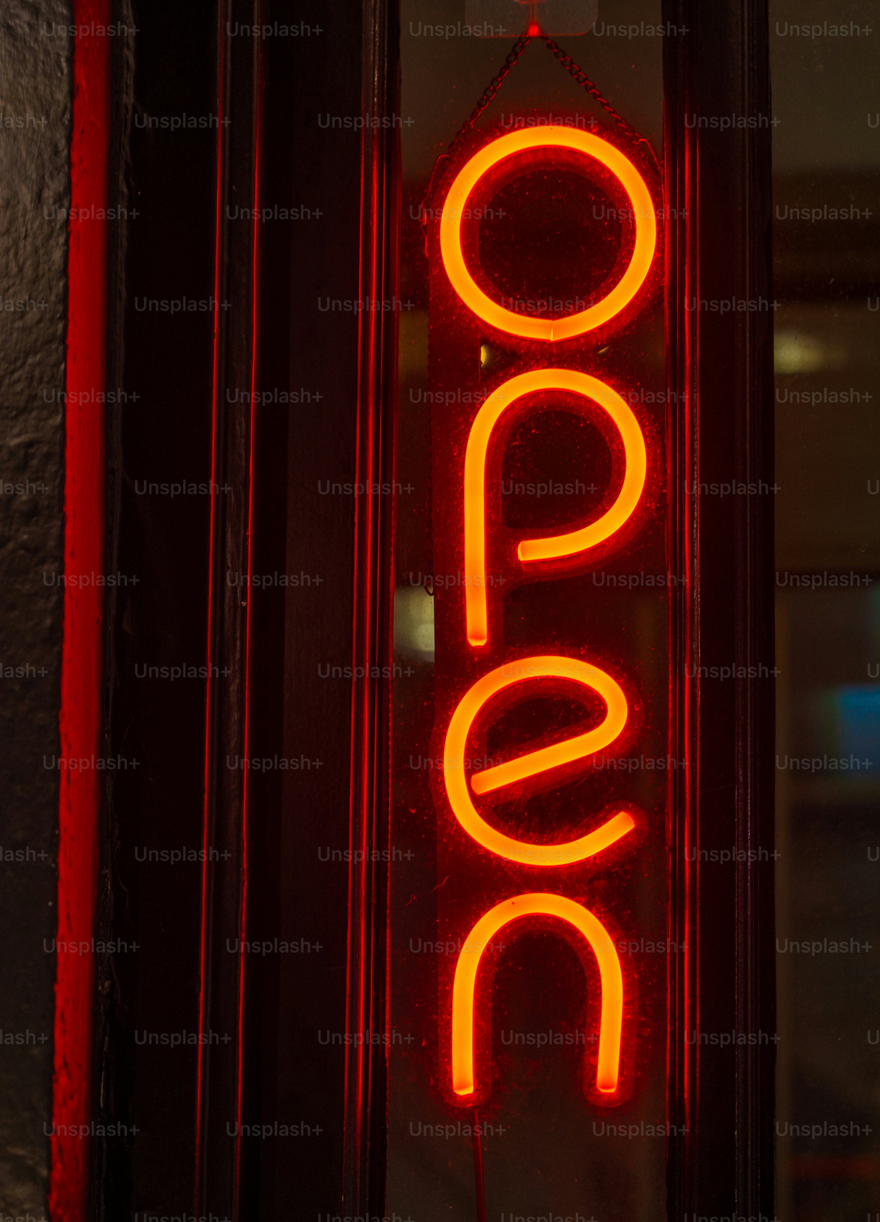 A close up of a neon sign on a building photo – Neon light Image on ...
