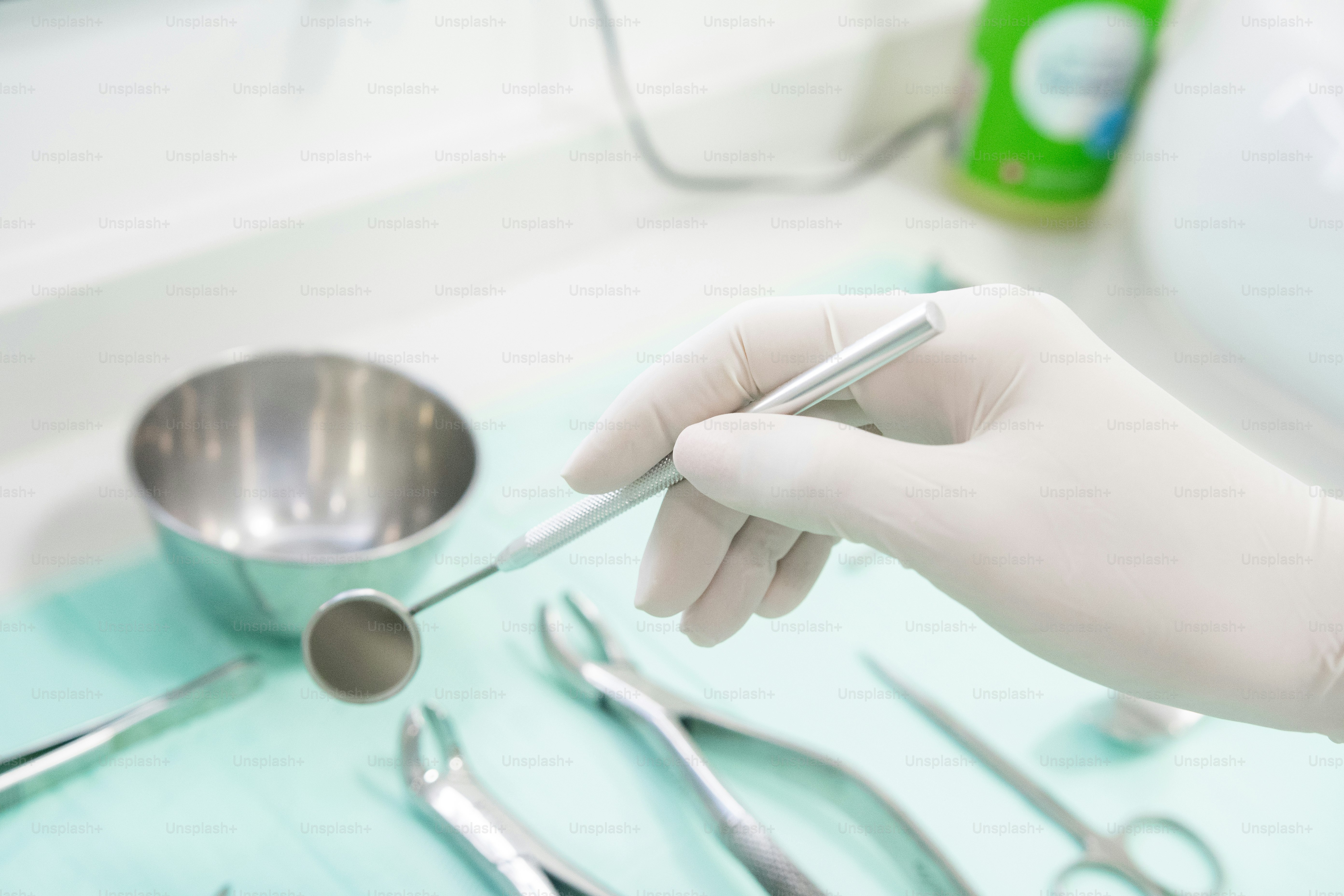 A gloved hand holding a spoon over a sink photo – Dentist surgery Image ...