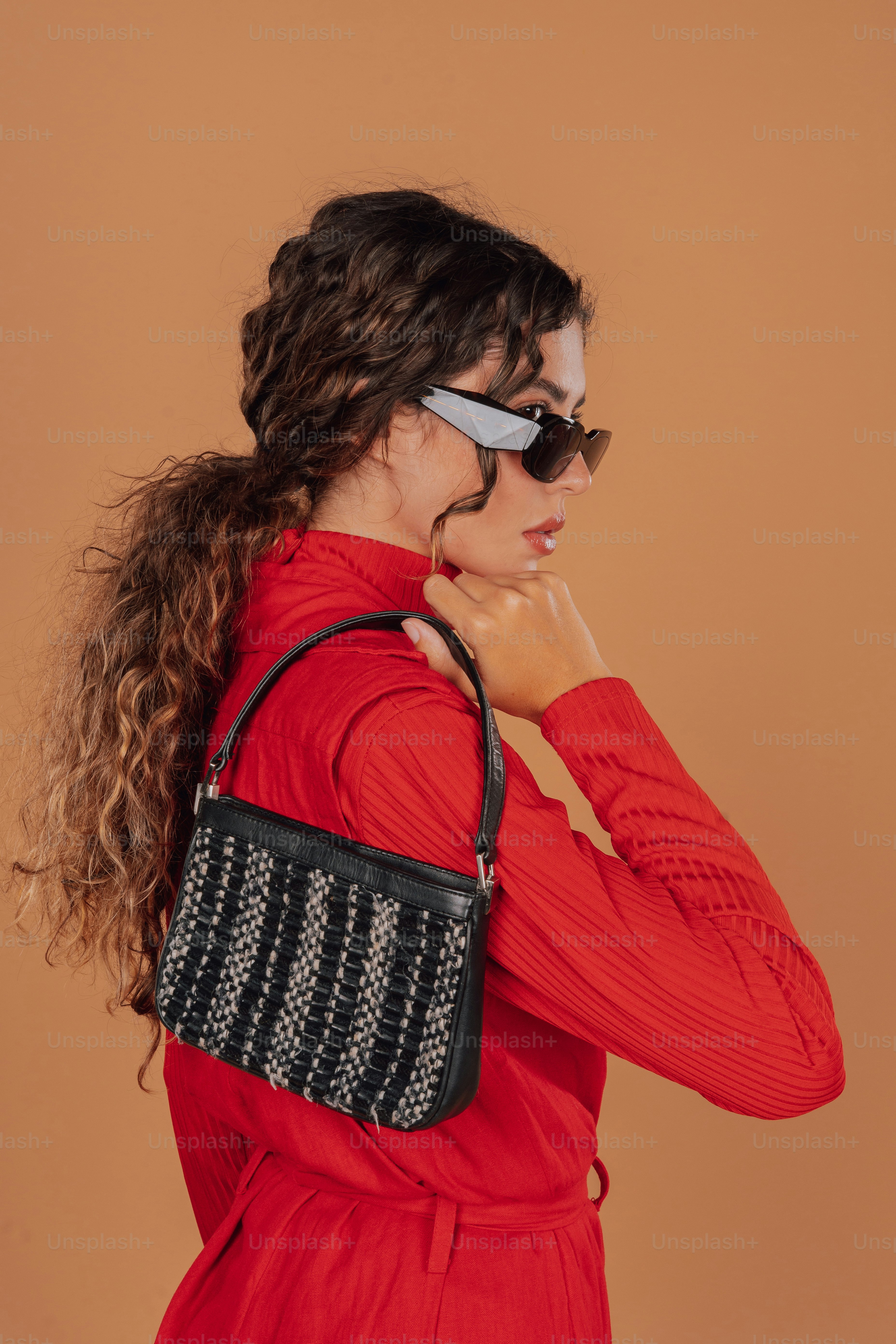 A woman in a red dress holding a black purse photo – Side profile Image ...