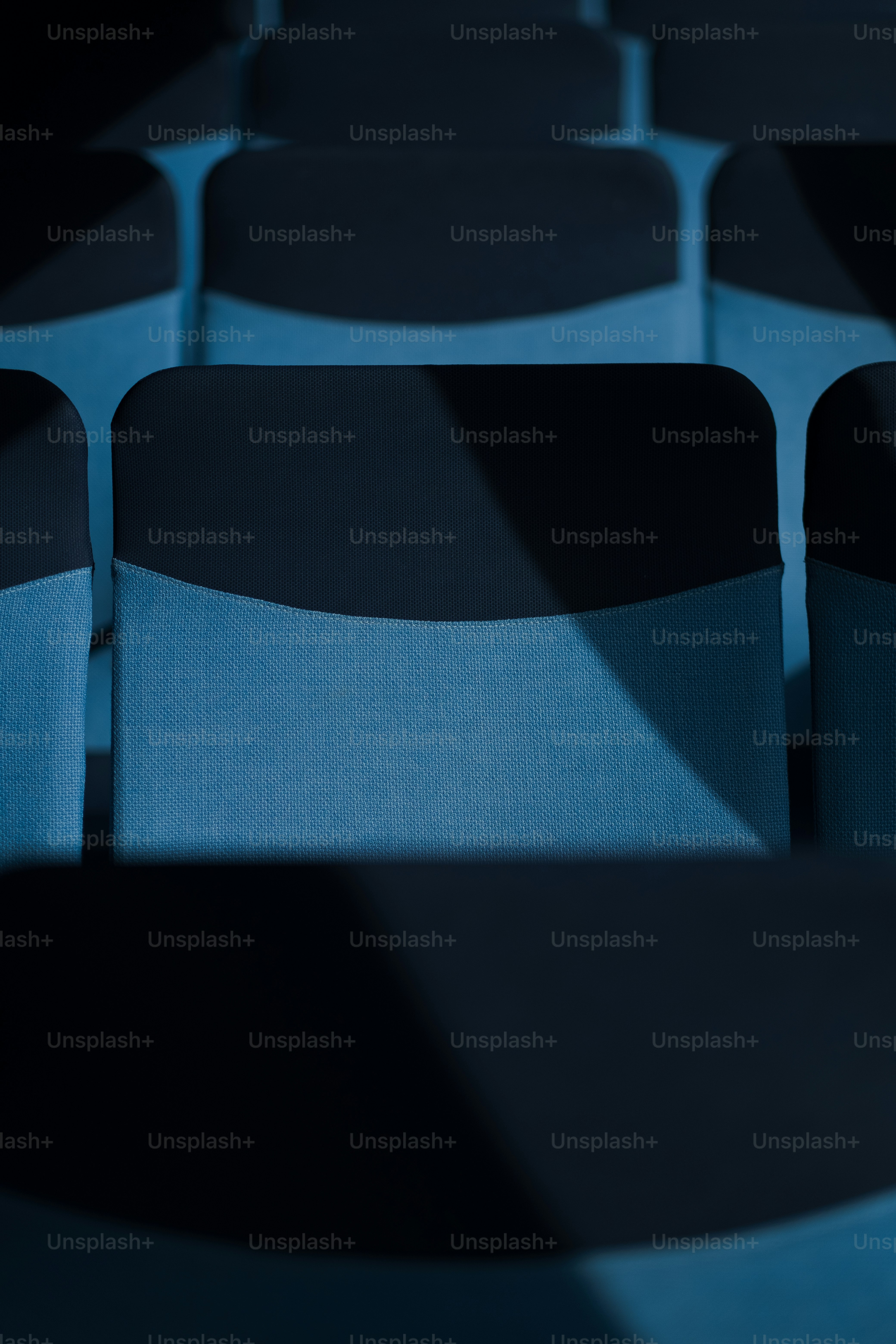 A row of blue seats sitting next to each other photo – Blue seats Image ...