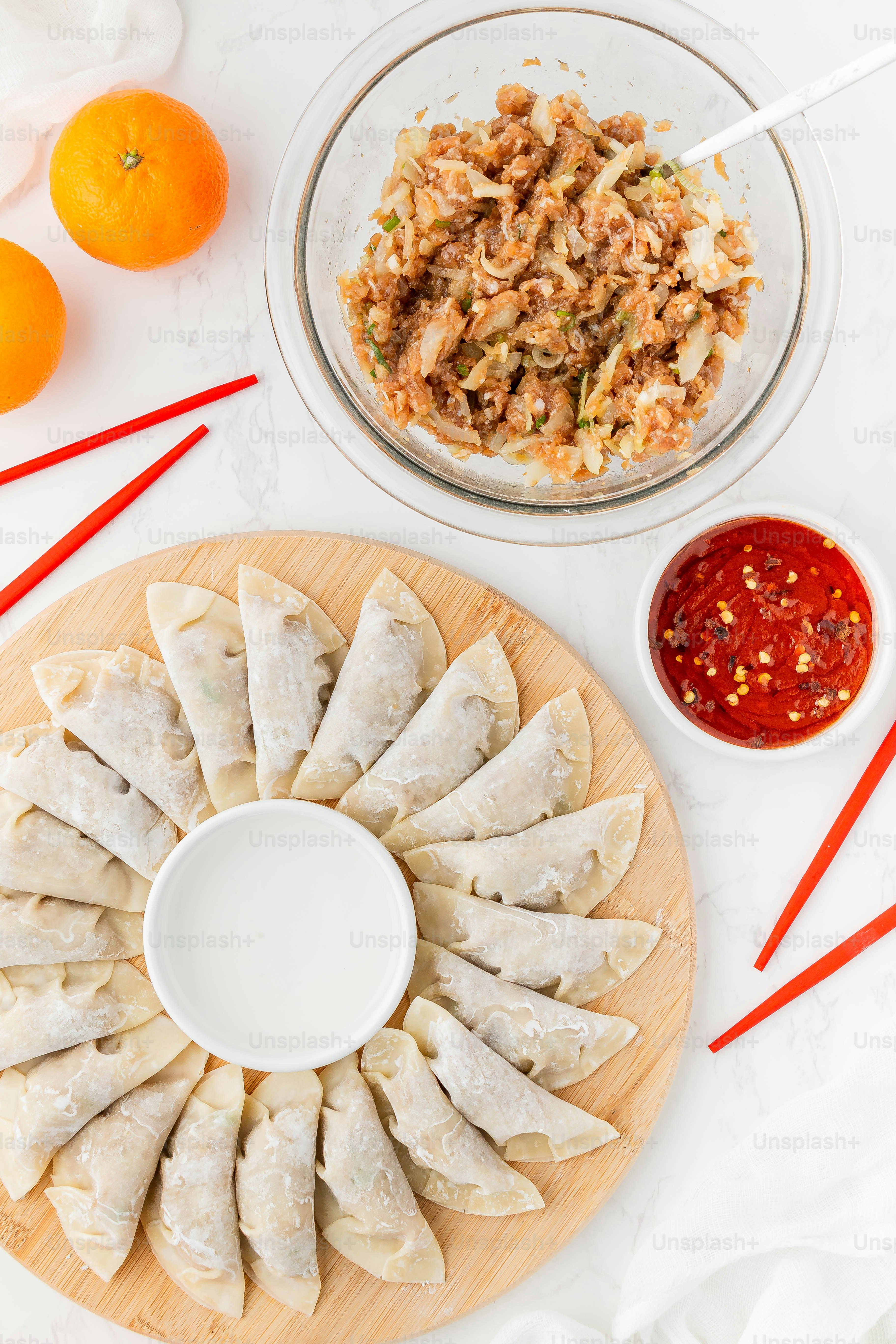 A plate of dumplings and a bowl of dipping sauce photo – Chinese food ...