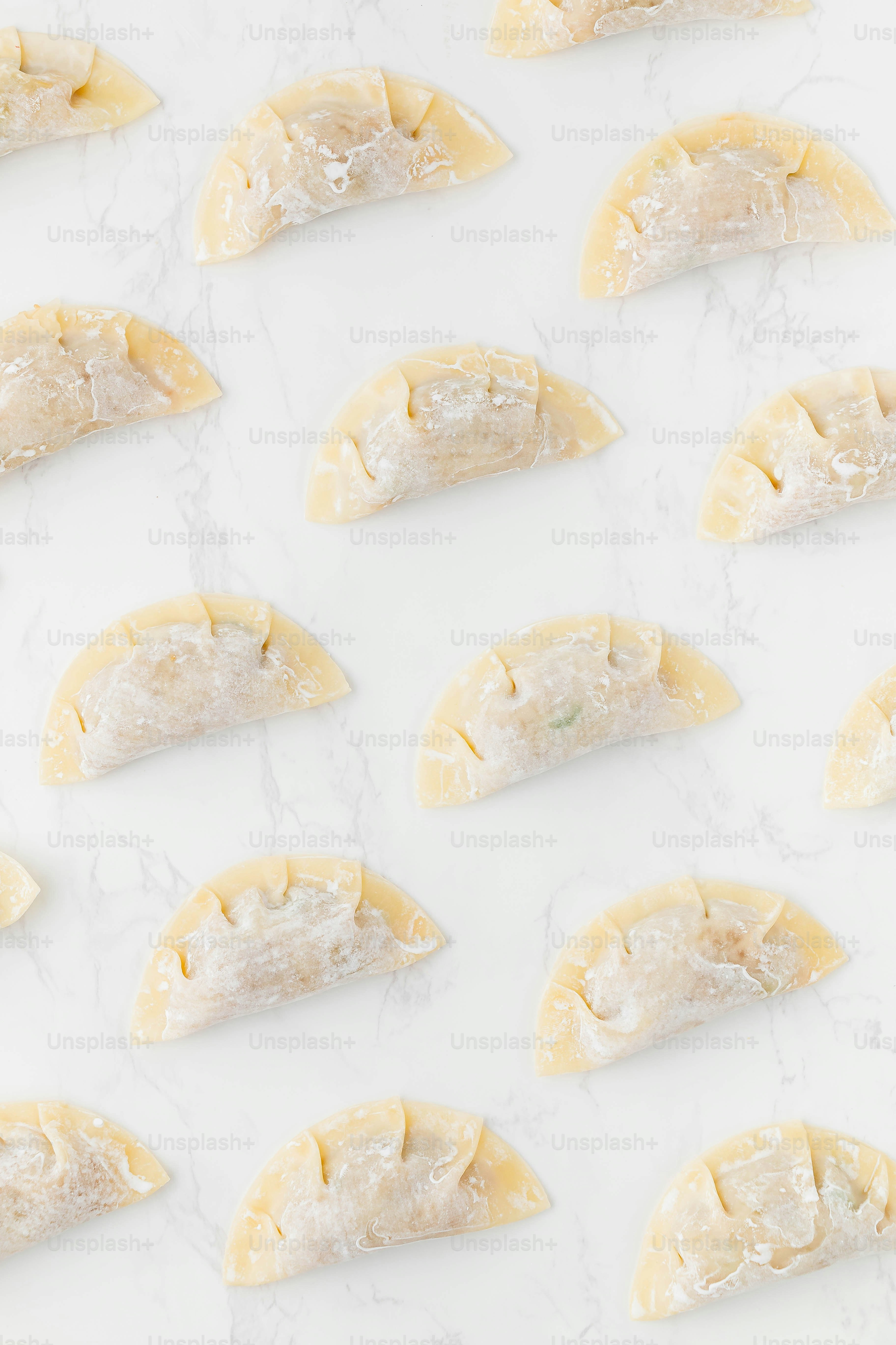 A group of dumplings sitting on top of a white counter photo – Chinese ...