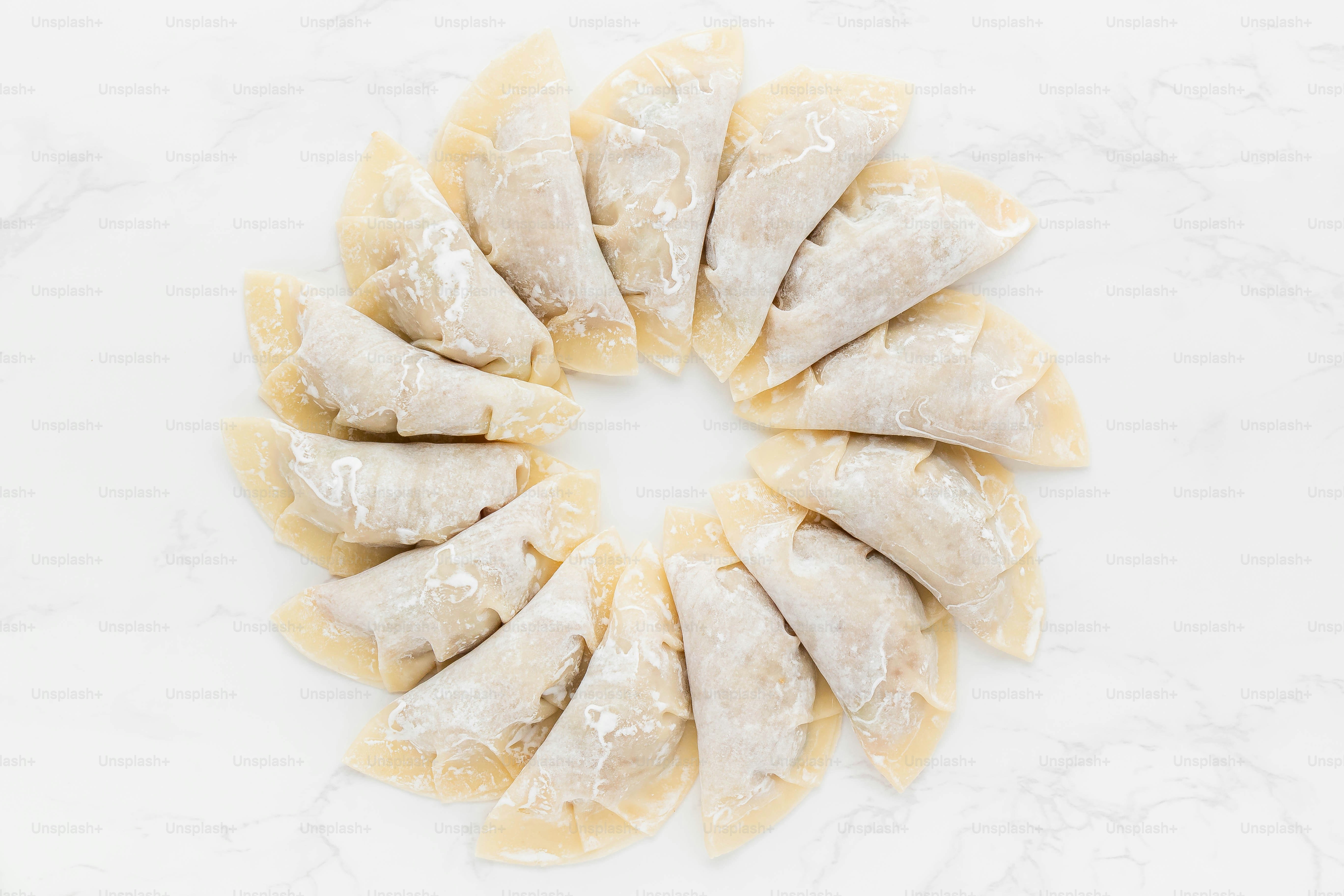 A circular arrangement of dumplings on a marble surface photo – Chinese ...