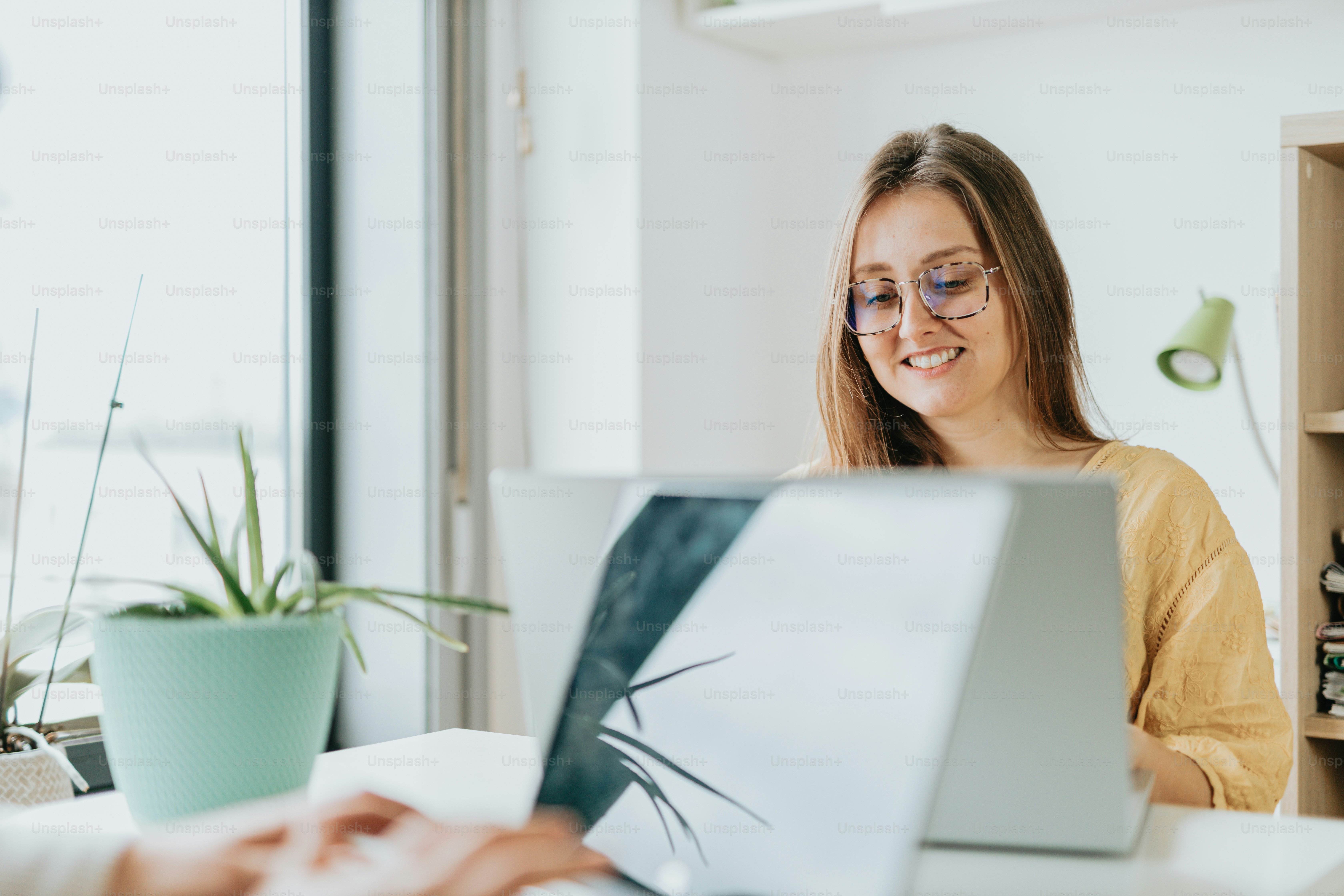 A woman sitting in front of a laptop computer photo – Working at home ...