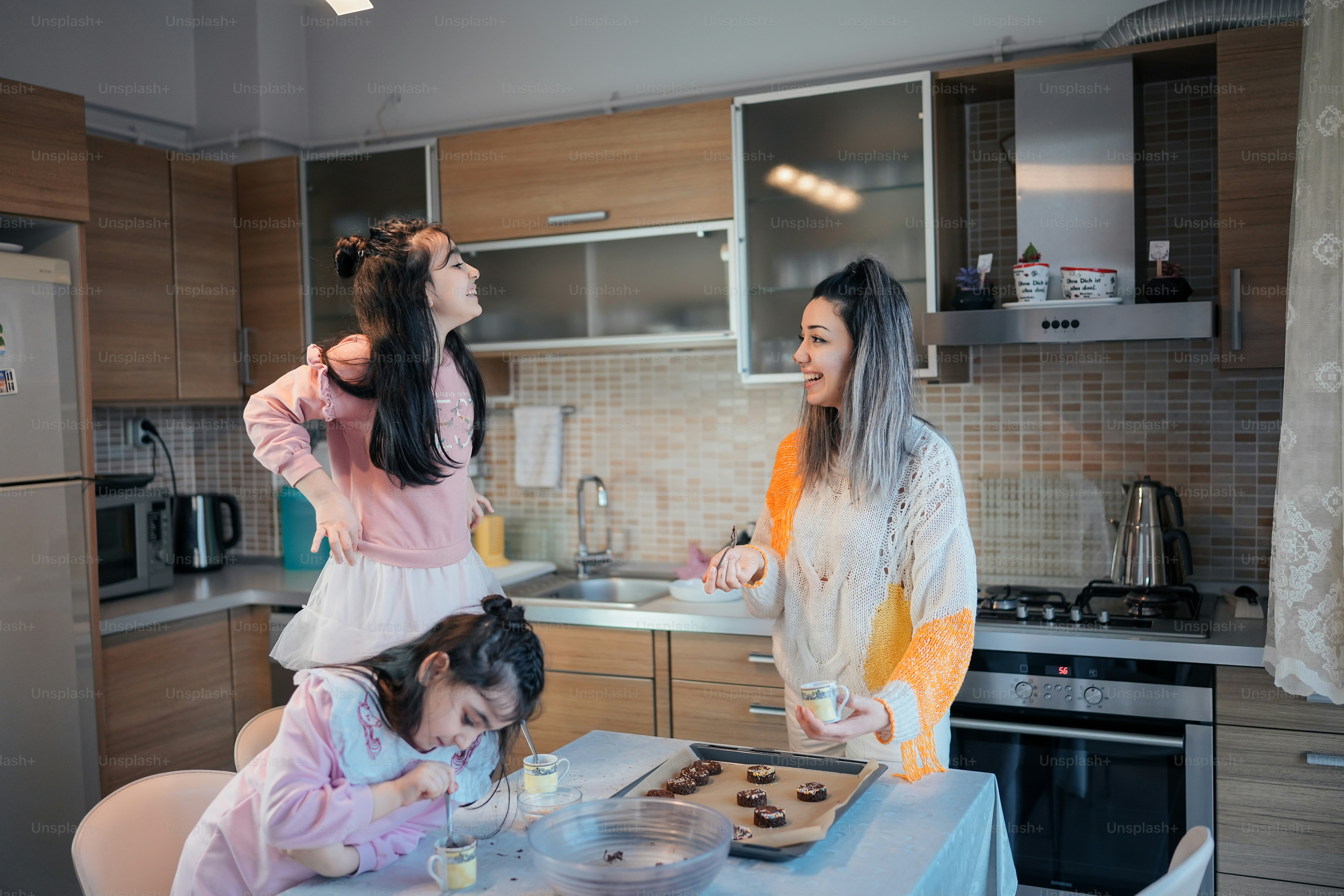 A group of women standing around a kitchen table photo – Kitchen Image ...