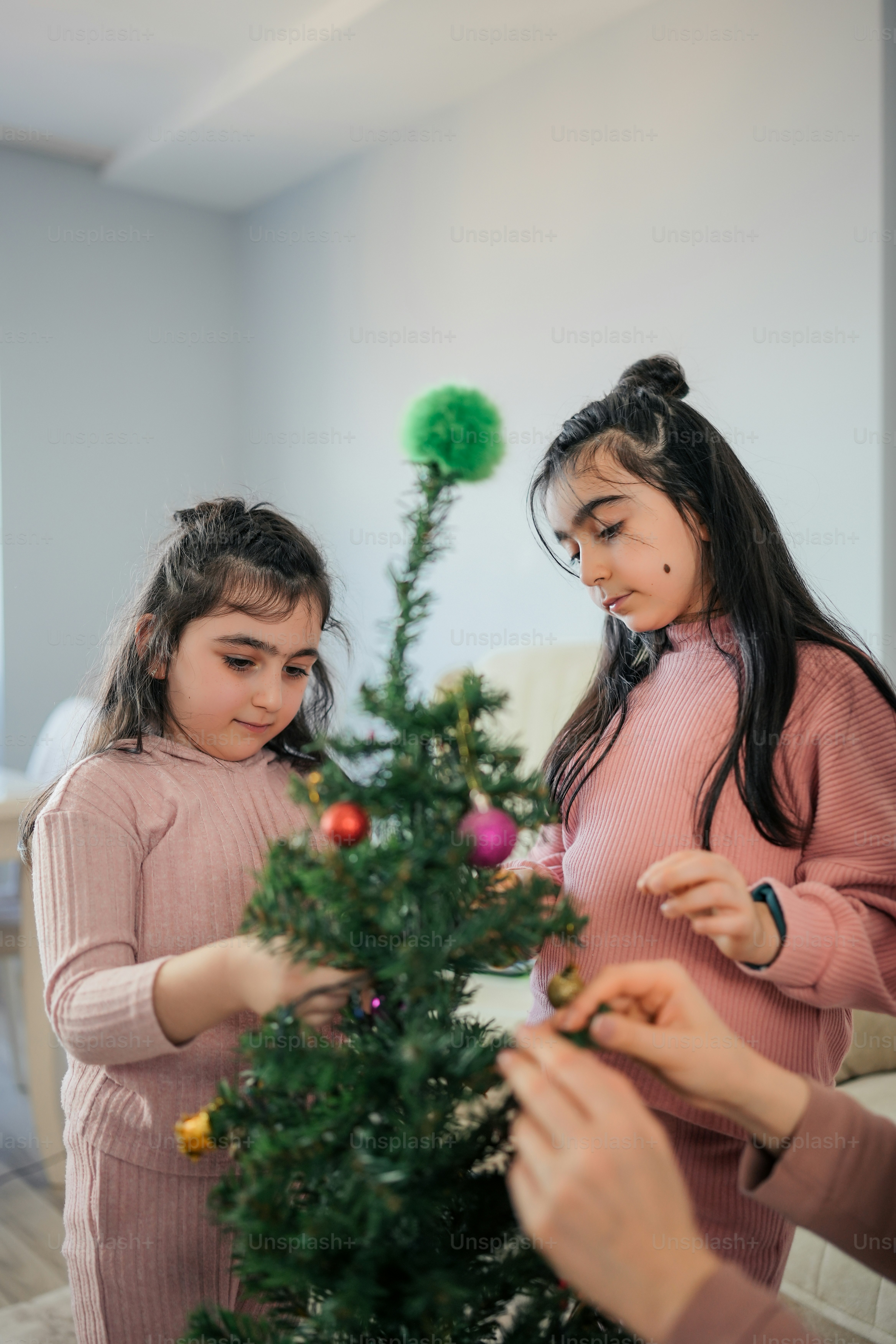Two girls decorating a christmas tree together photo – Decorating Image ...
