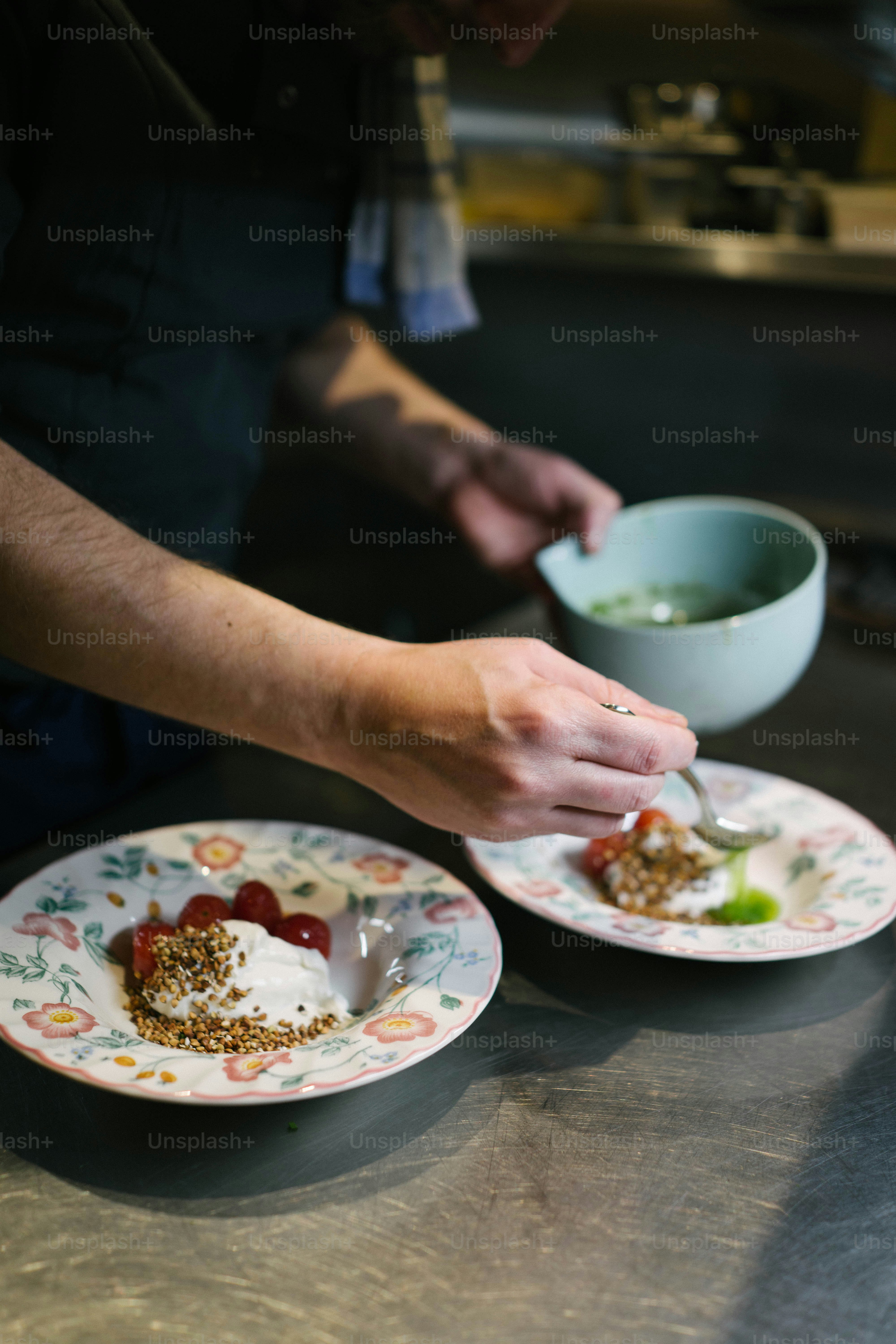 A person holding a spoon over a bowl of food photo – Professional chef ...