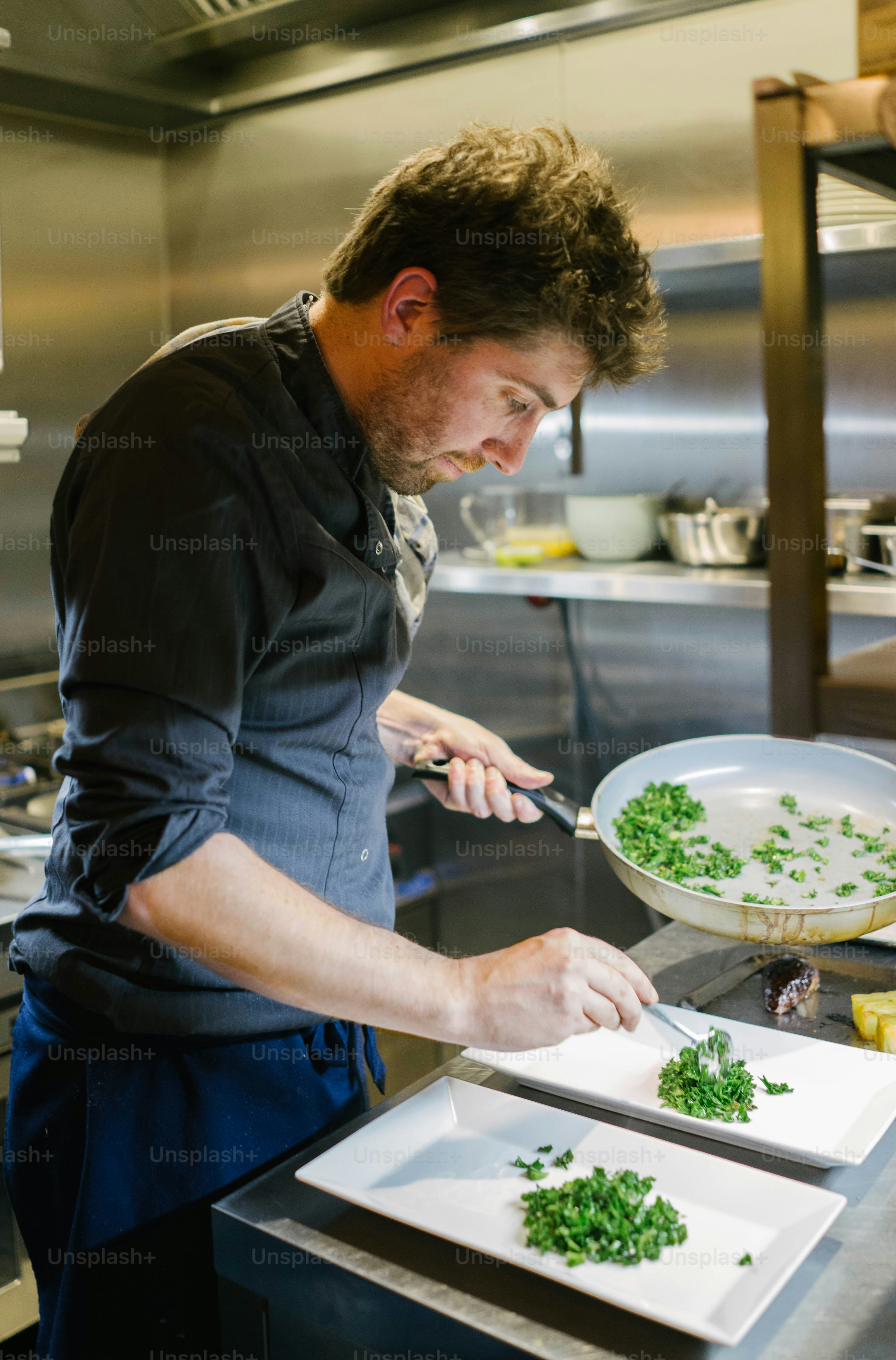 A man in a kitchen preparing food on a cutting board photo ...
