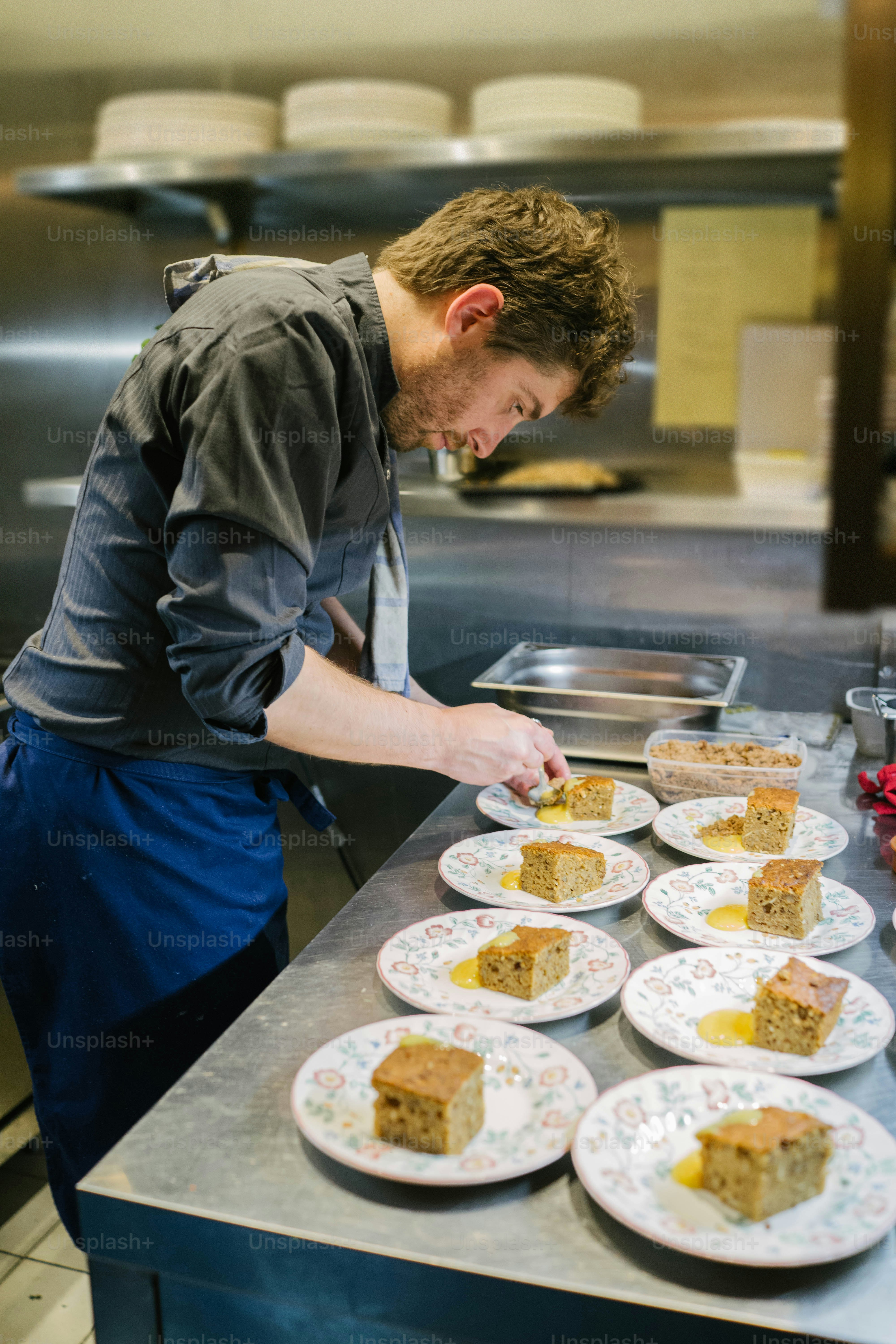A person in a kitchen preparing food on a plate photo – Fine dining ...