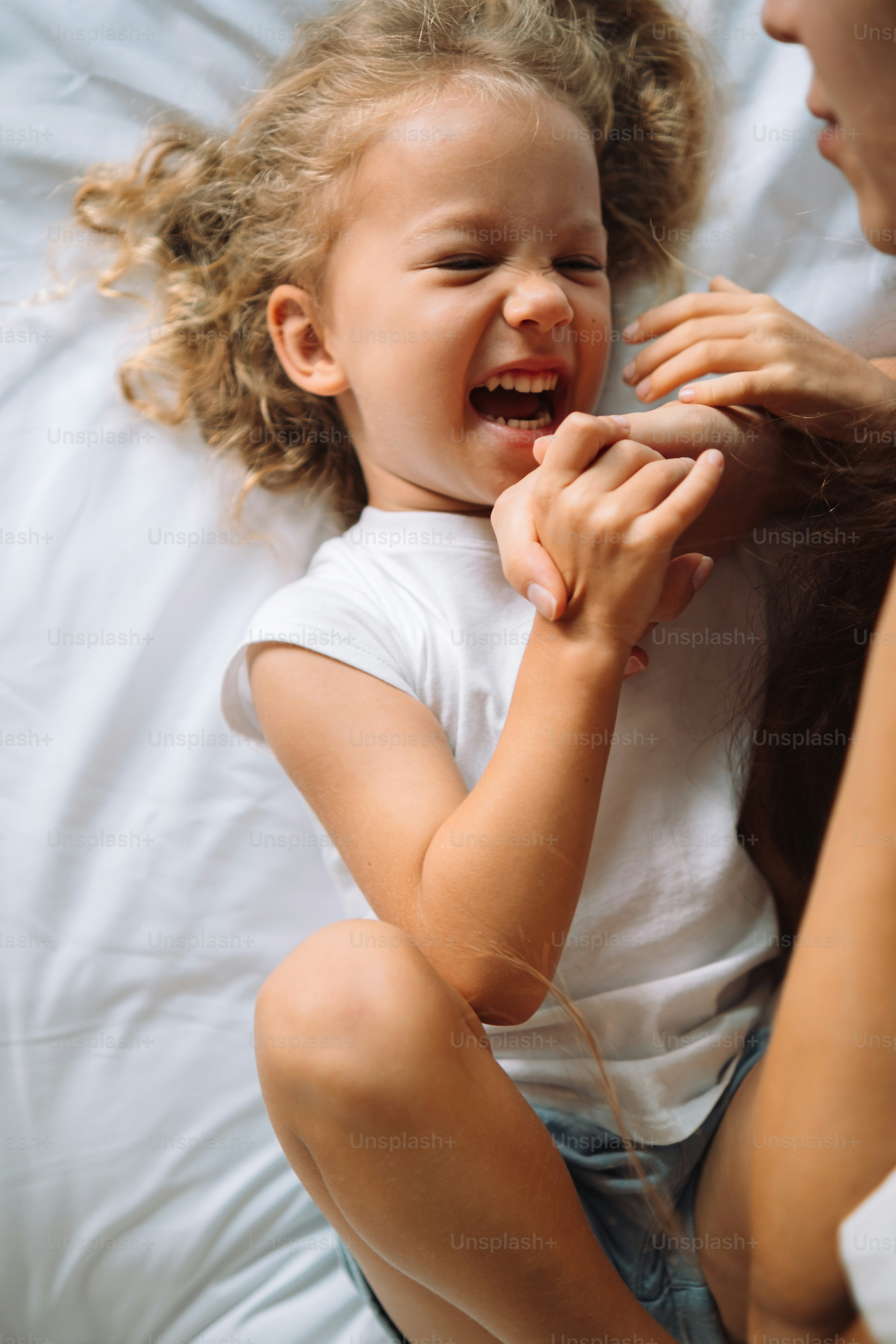 A little girl crying while being held by a woman photo – Family Image ...