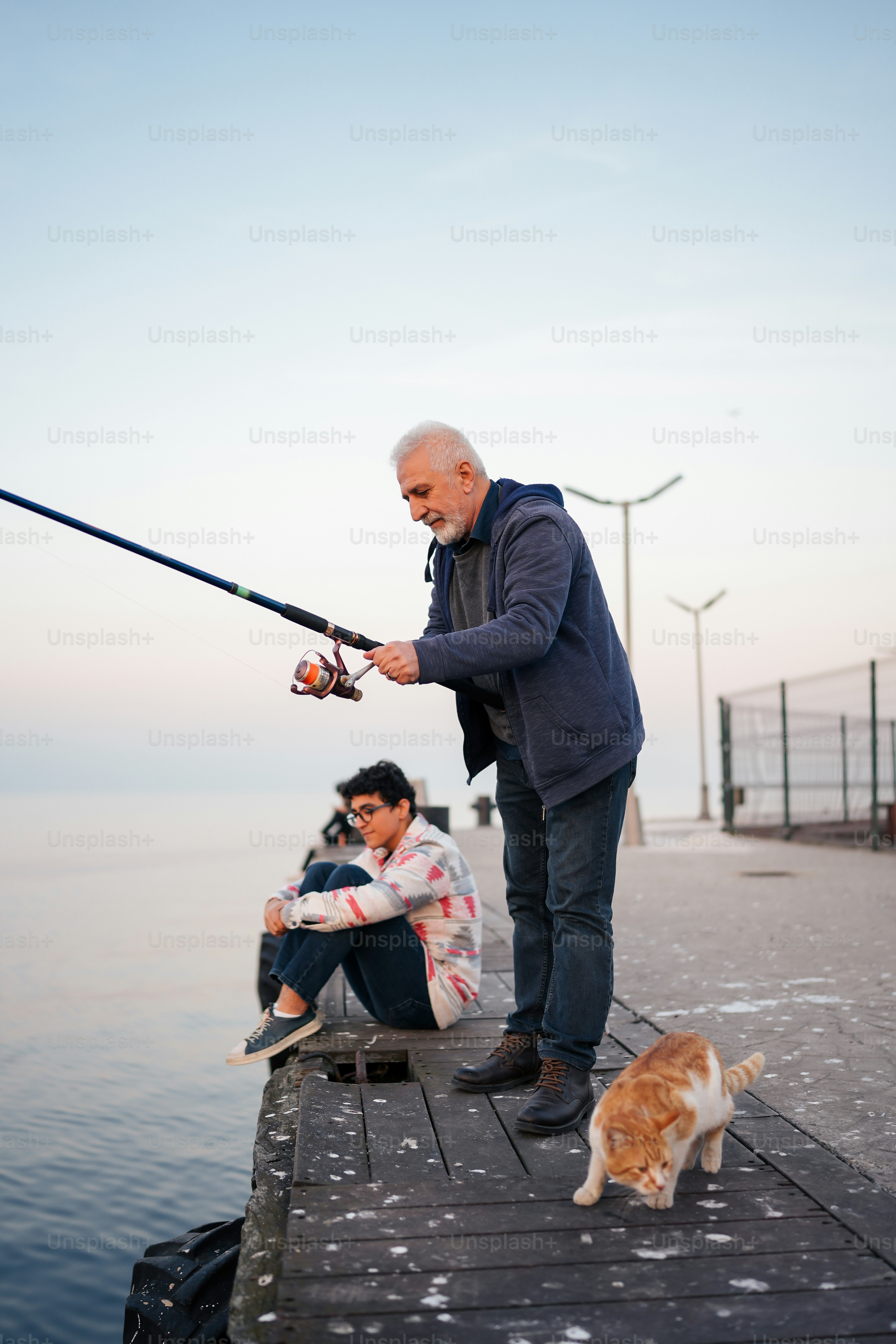 A man and a cat fishing on a pier photo – Cat Image on Unsplash