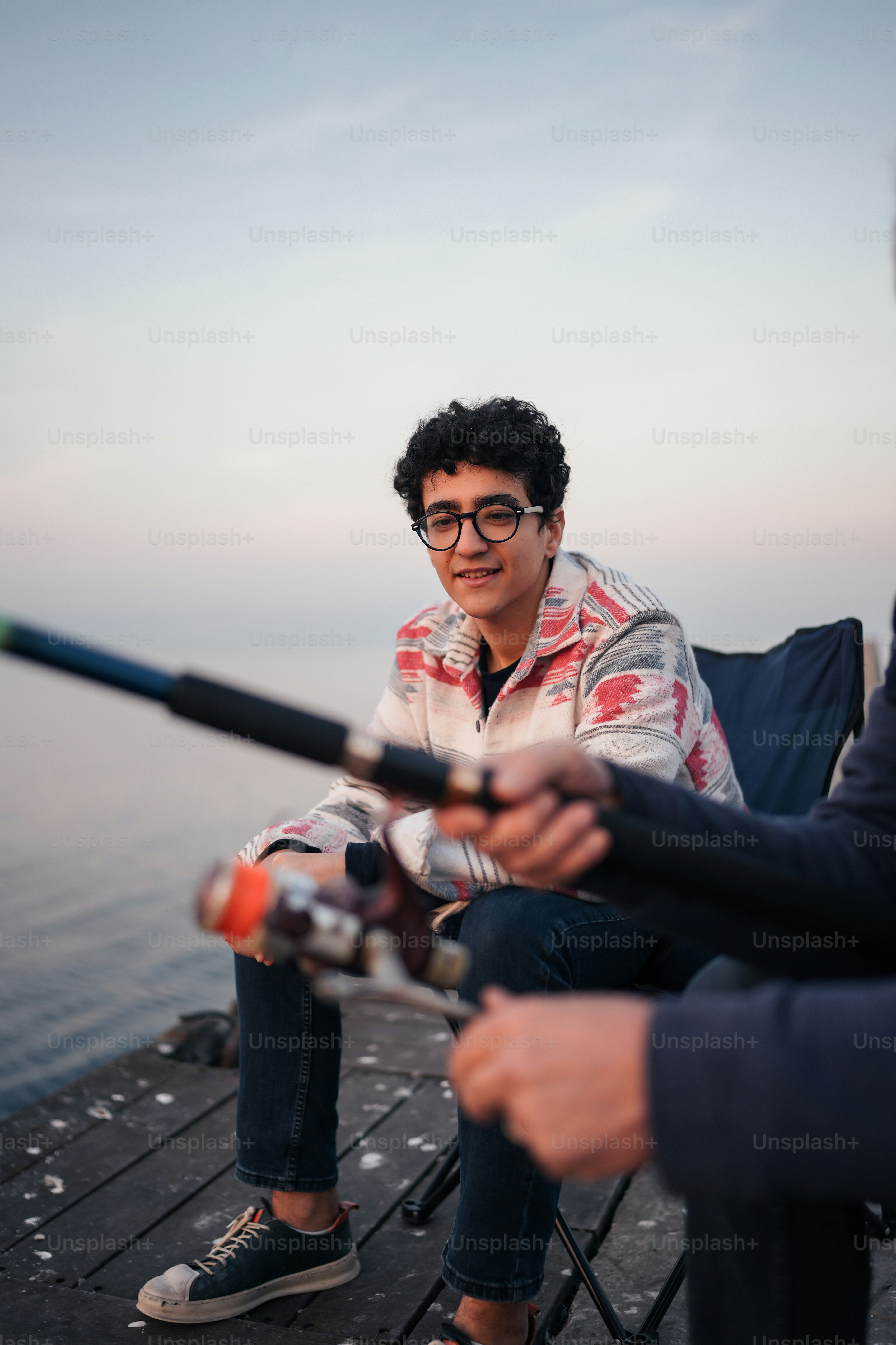 Foto Un hombre sentado en una silla sosteniendo una caña de pescar ...