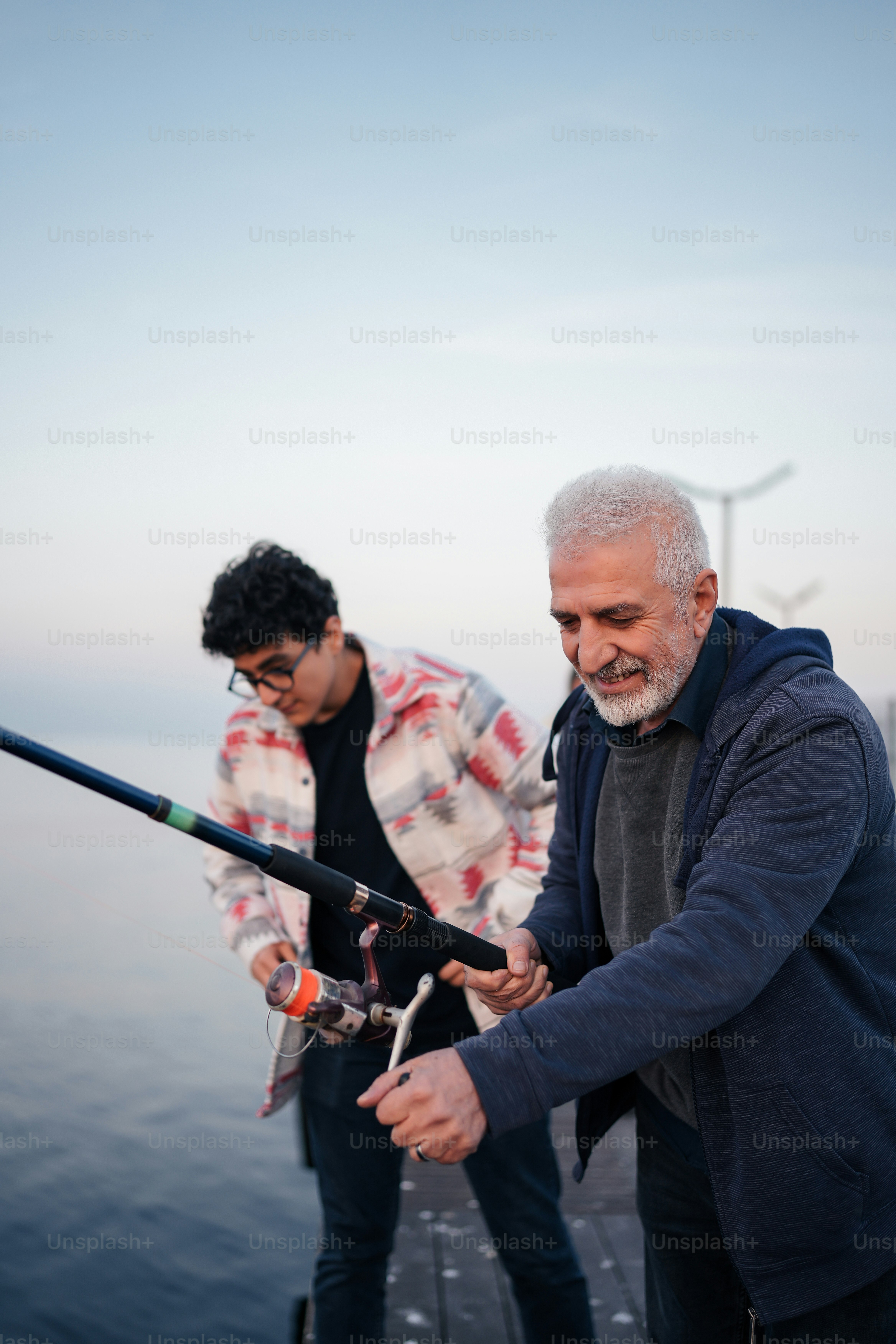 Foto Un hombre sosteniendo una caña de pescar junto a otro hombre ...