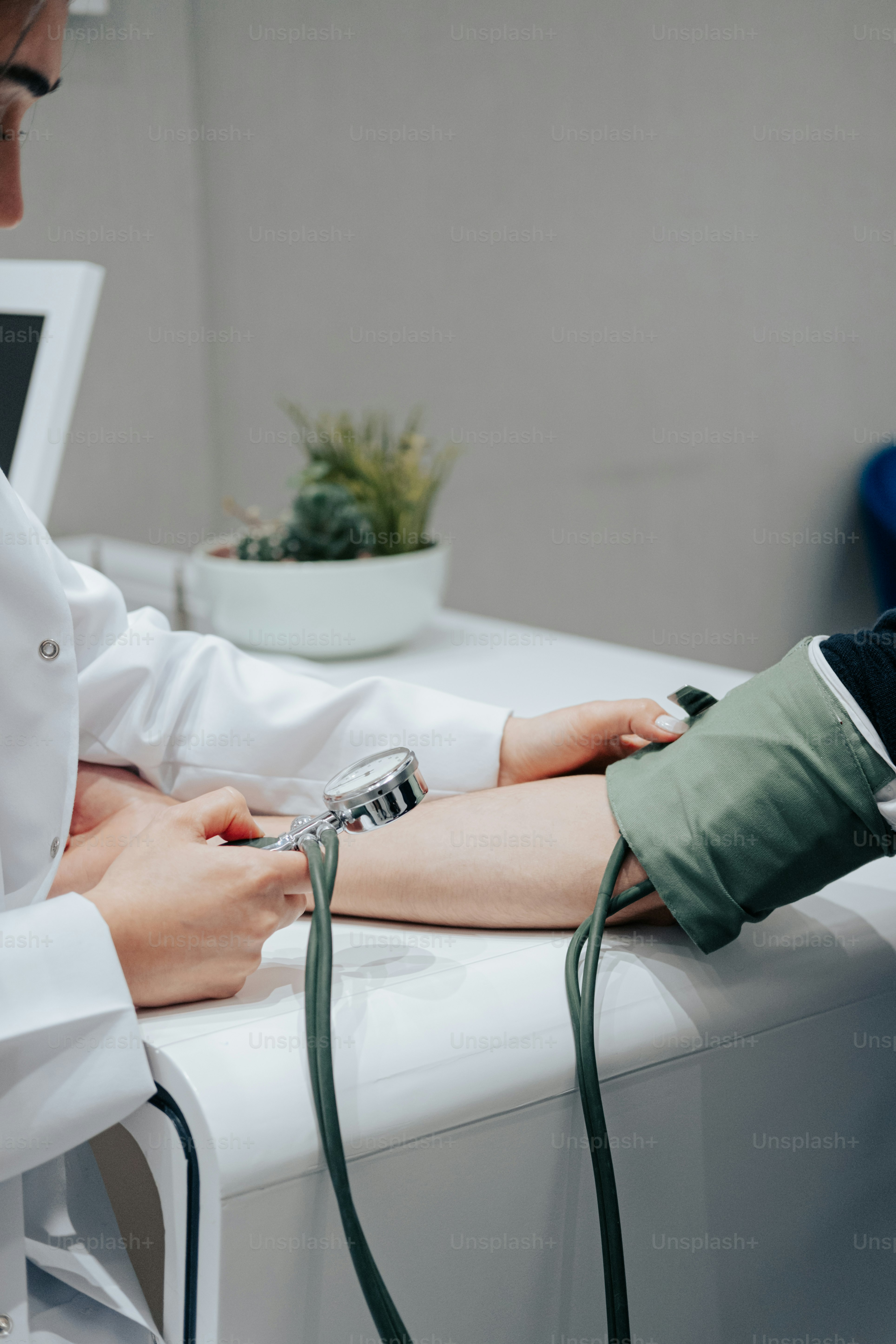 Un médecin vérifiant le bras d’un patient à l’aide d’un stéthoscope ...