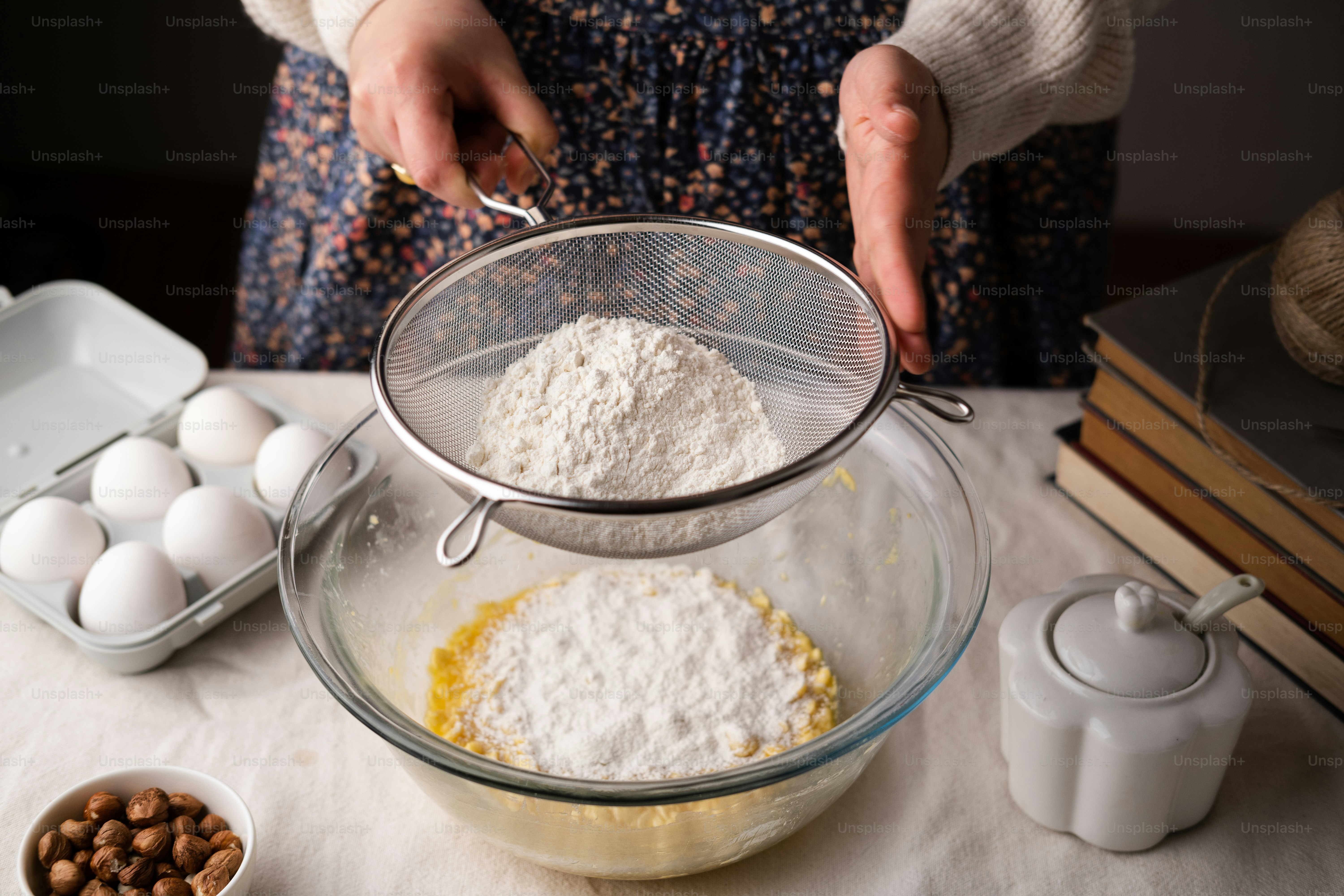 A person mixing ingredients in a bowl on a table photo – Ingredients ...
