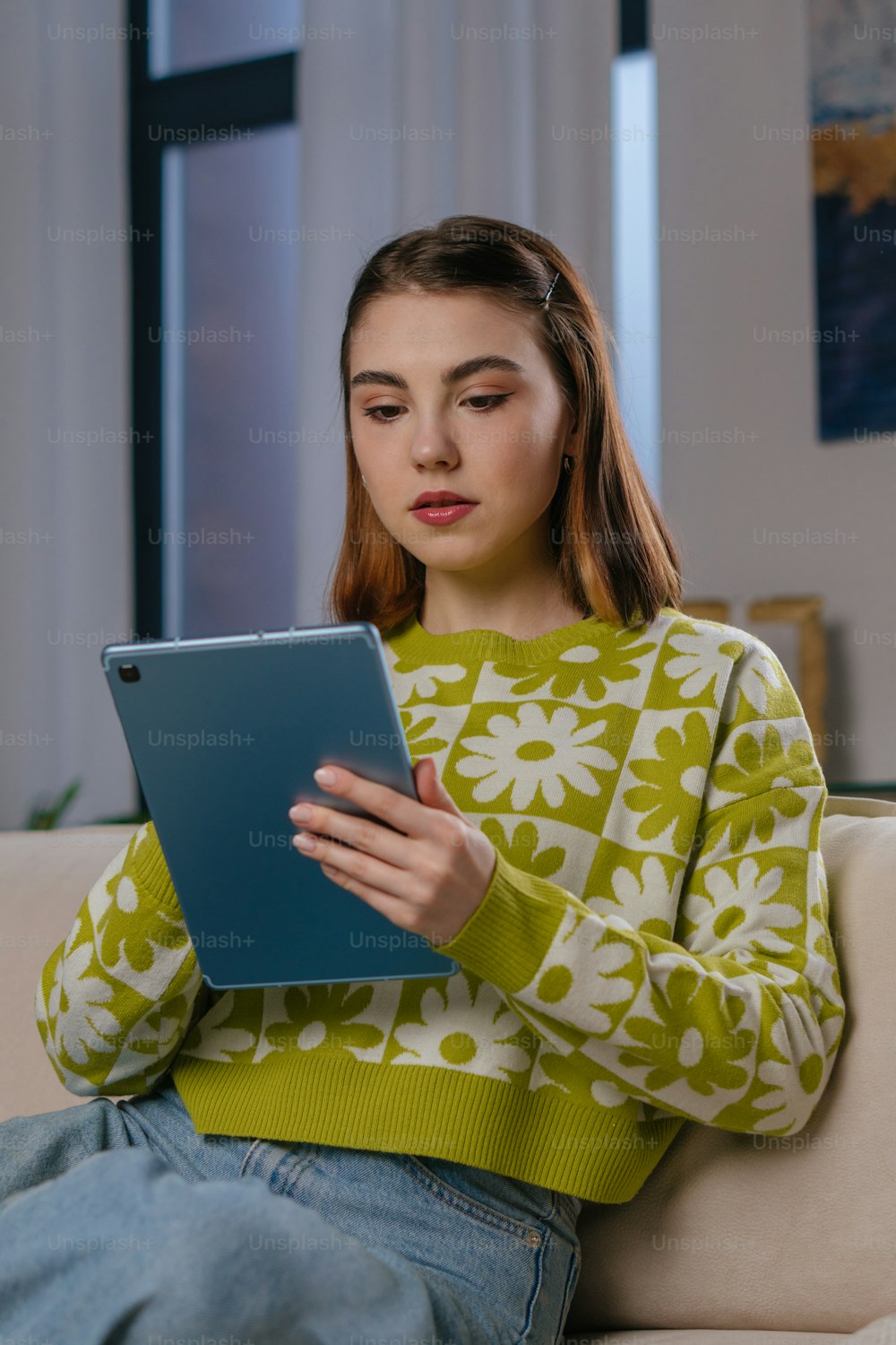 Una mujer sentada en un sofá usando una computadora portátil foto ... Una mujer sentada en un sofá usando una computadora portátil foto ...