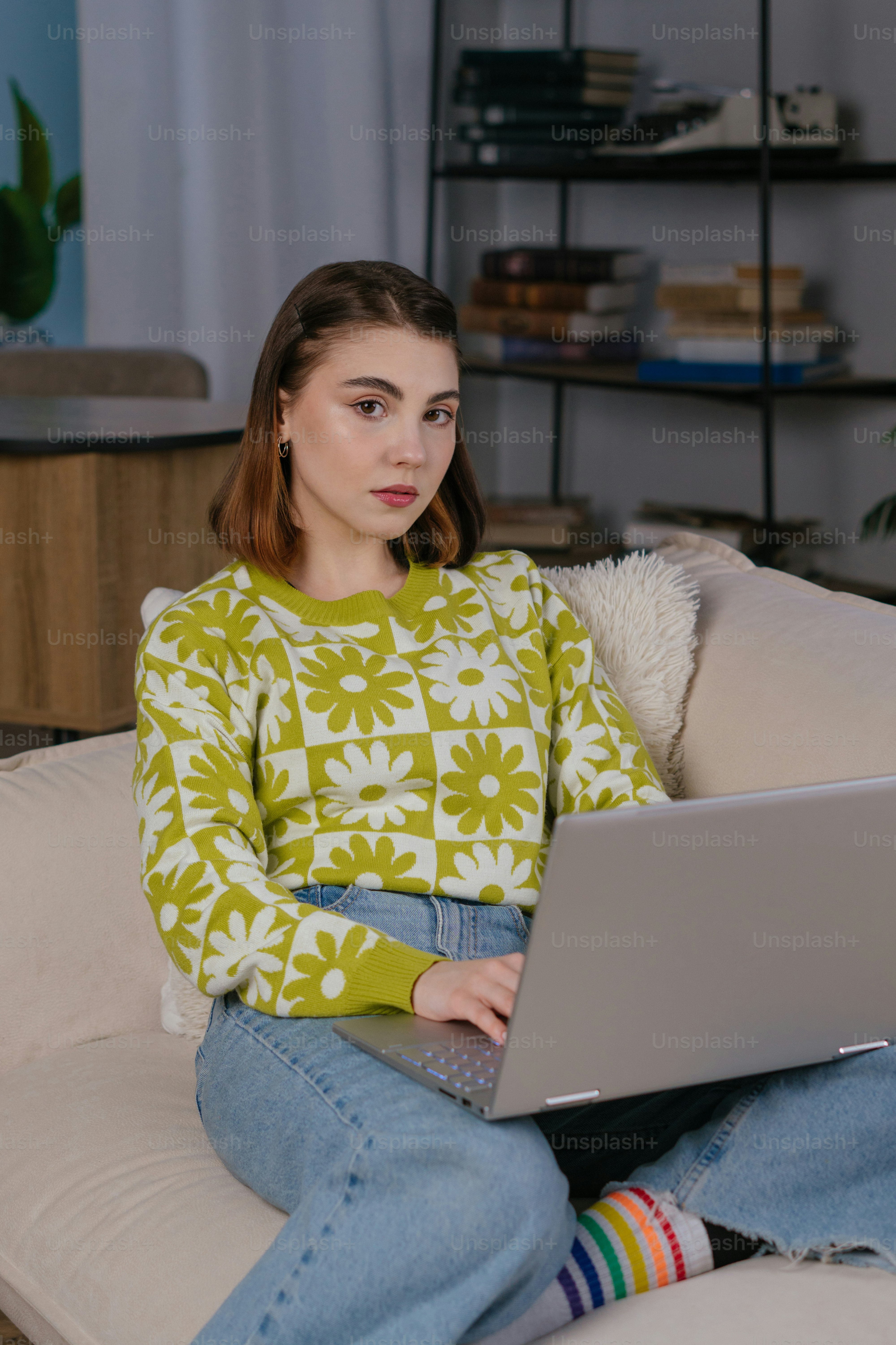 A woman sitting on a couch using a laptop computer photo – Ukraine ...